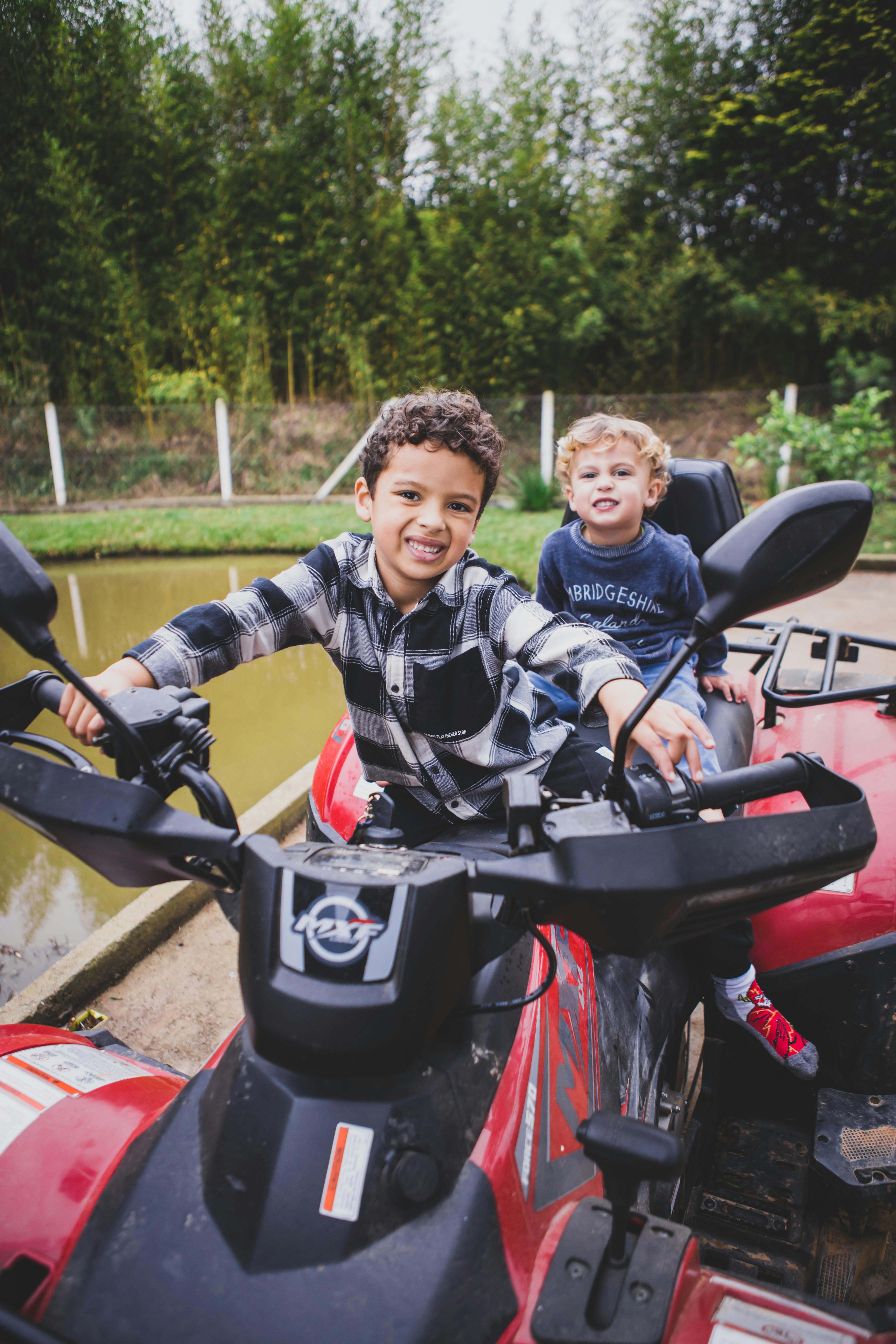Smiling Boys Riding on Scooters · Free Stock Photo