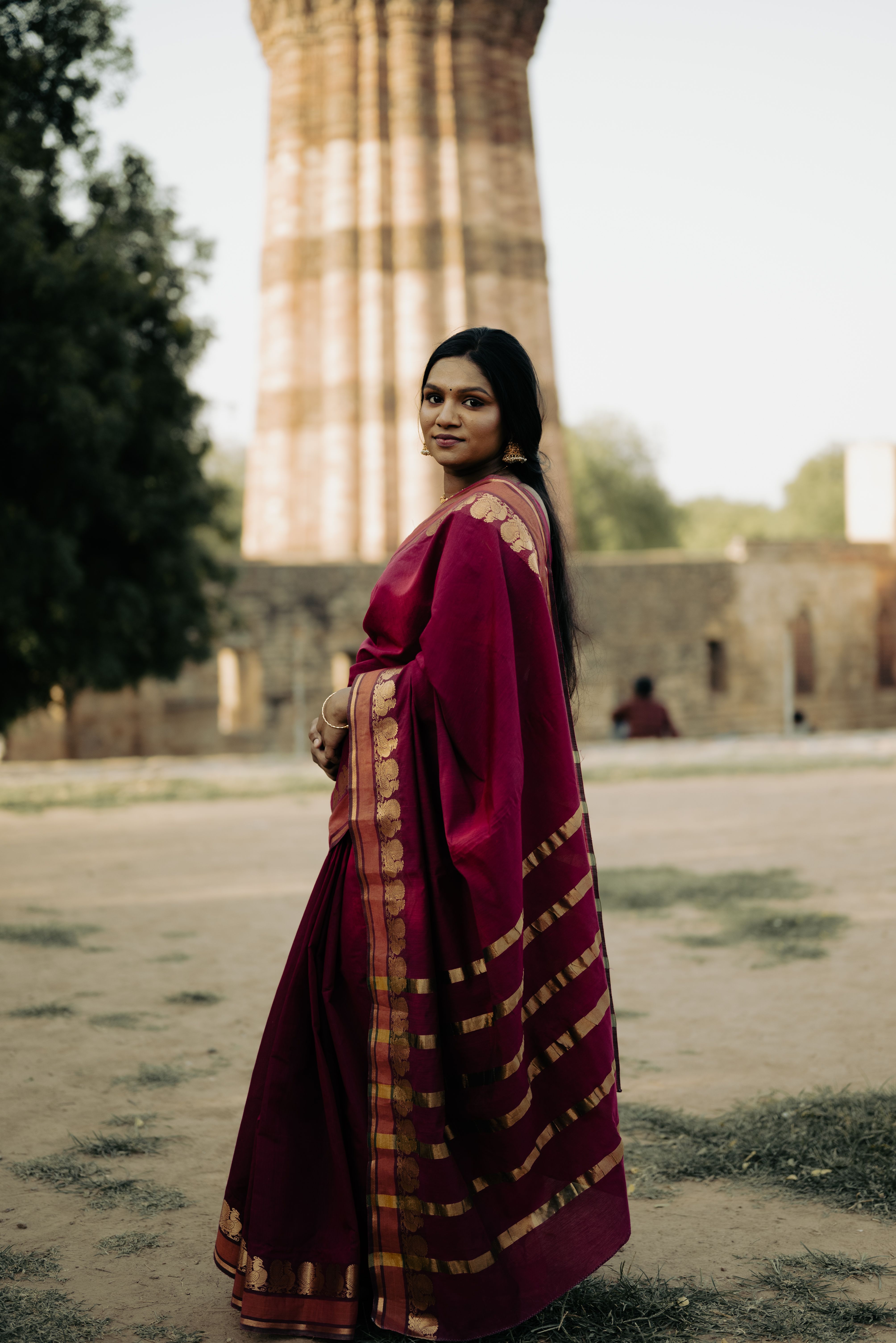 Photo of a Woman Wearing Red Sari Standing on a Street against a Tower ...