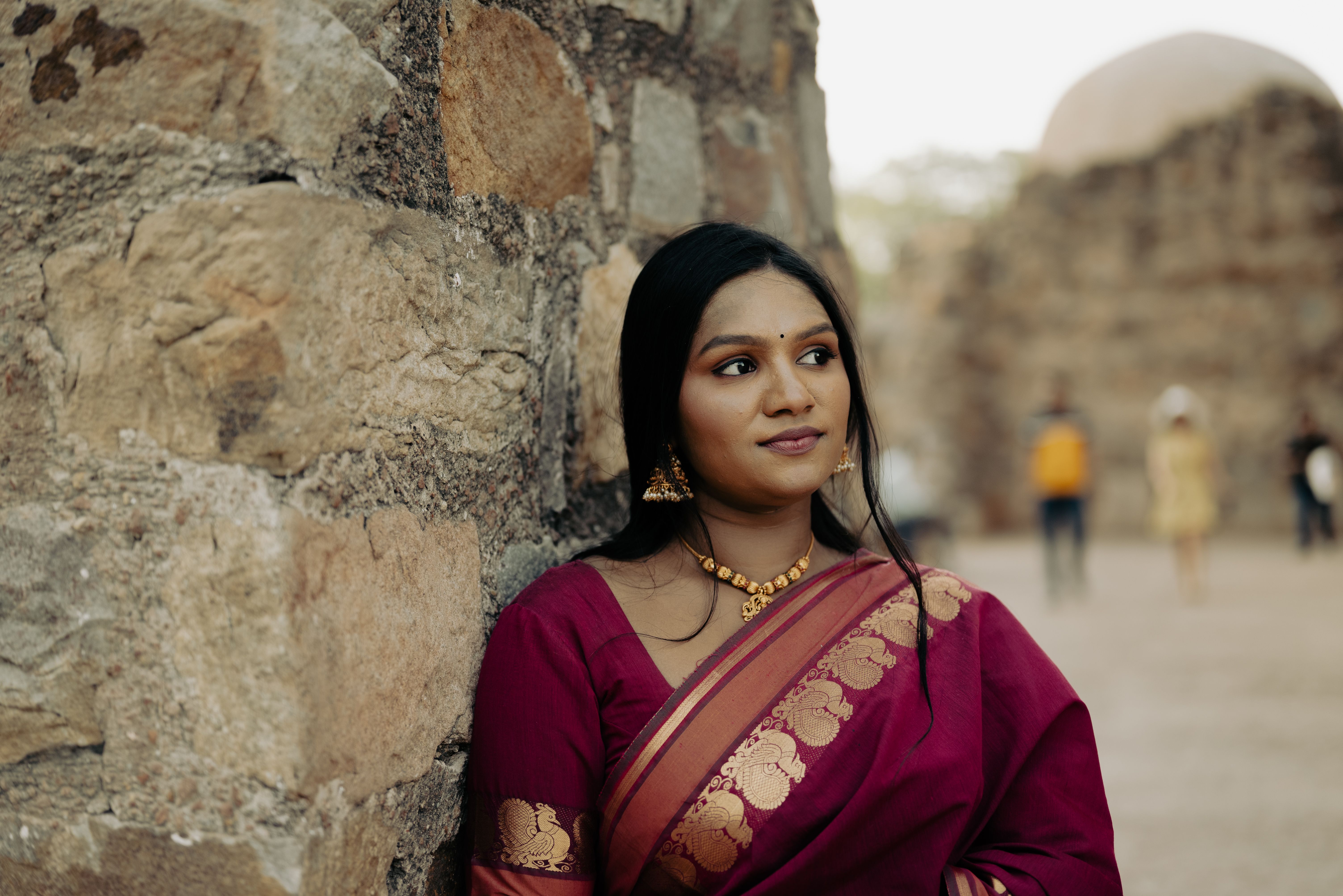 Young Woman in Sari Posing near Stone Wall · Free Stock Photo