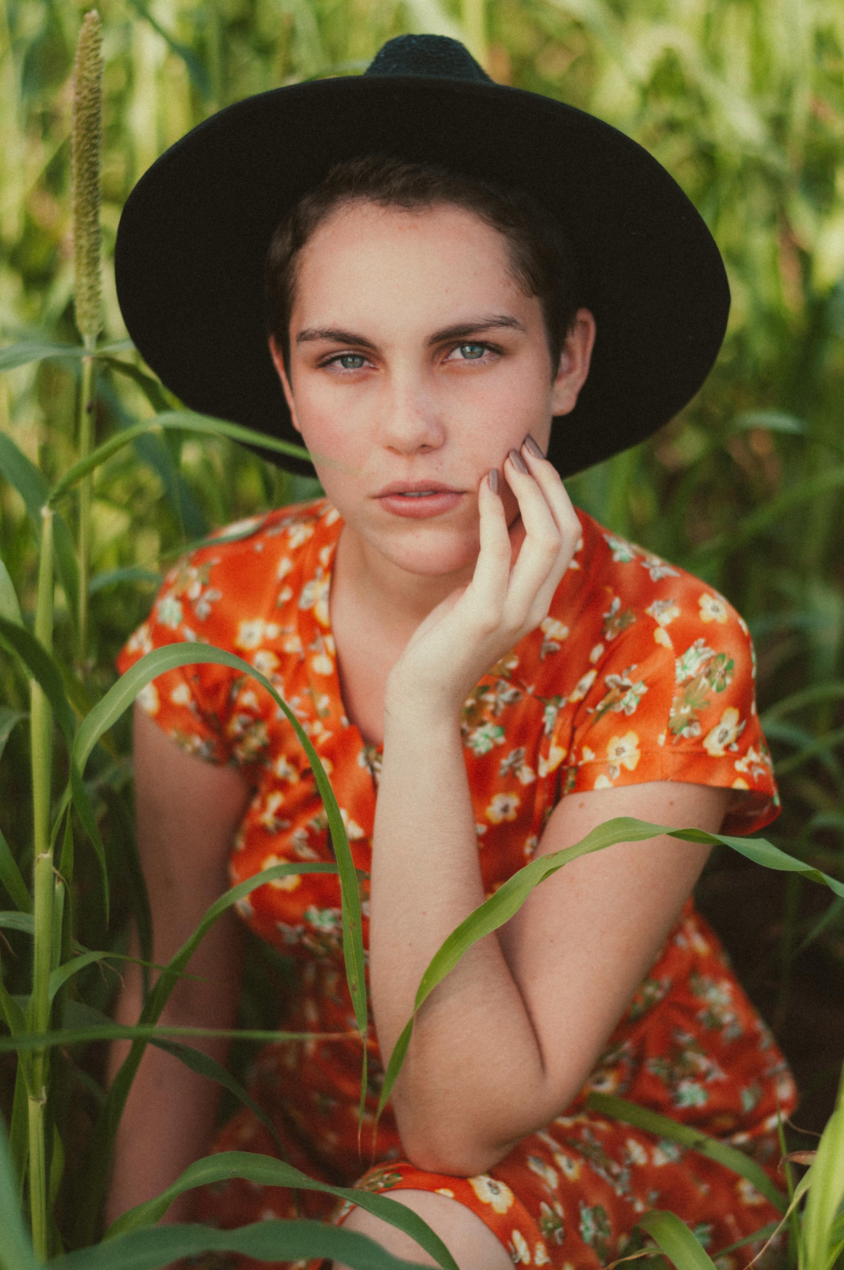 Model in Hat Posing in Field · Free Stock Photo