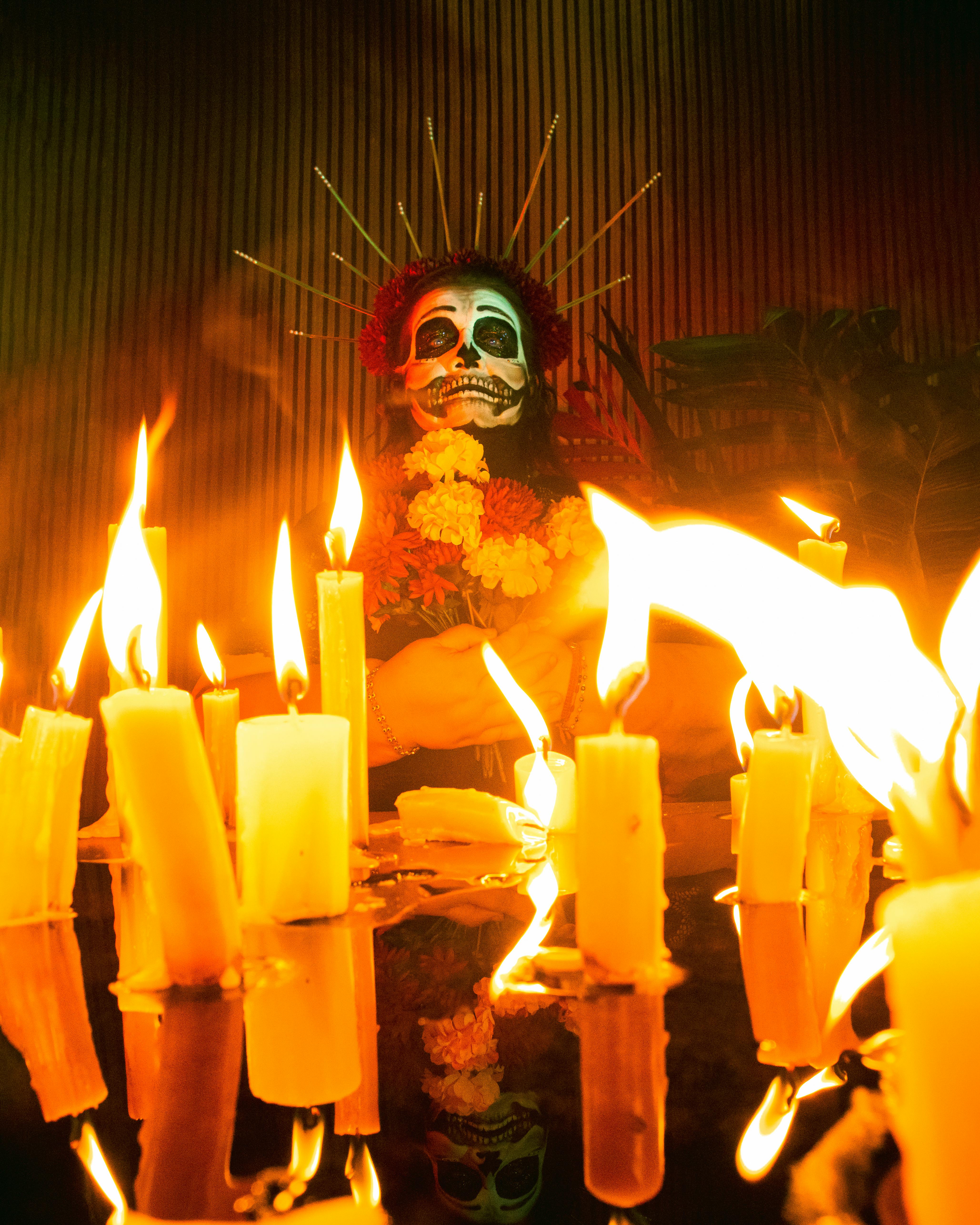 Catrina Sitting behind Wax Candles on Altar · Free Stock Photo