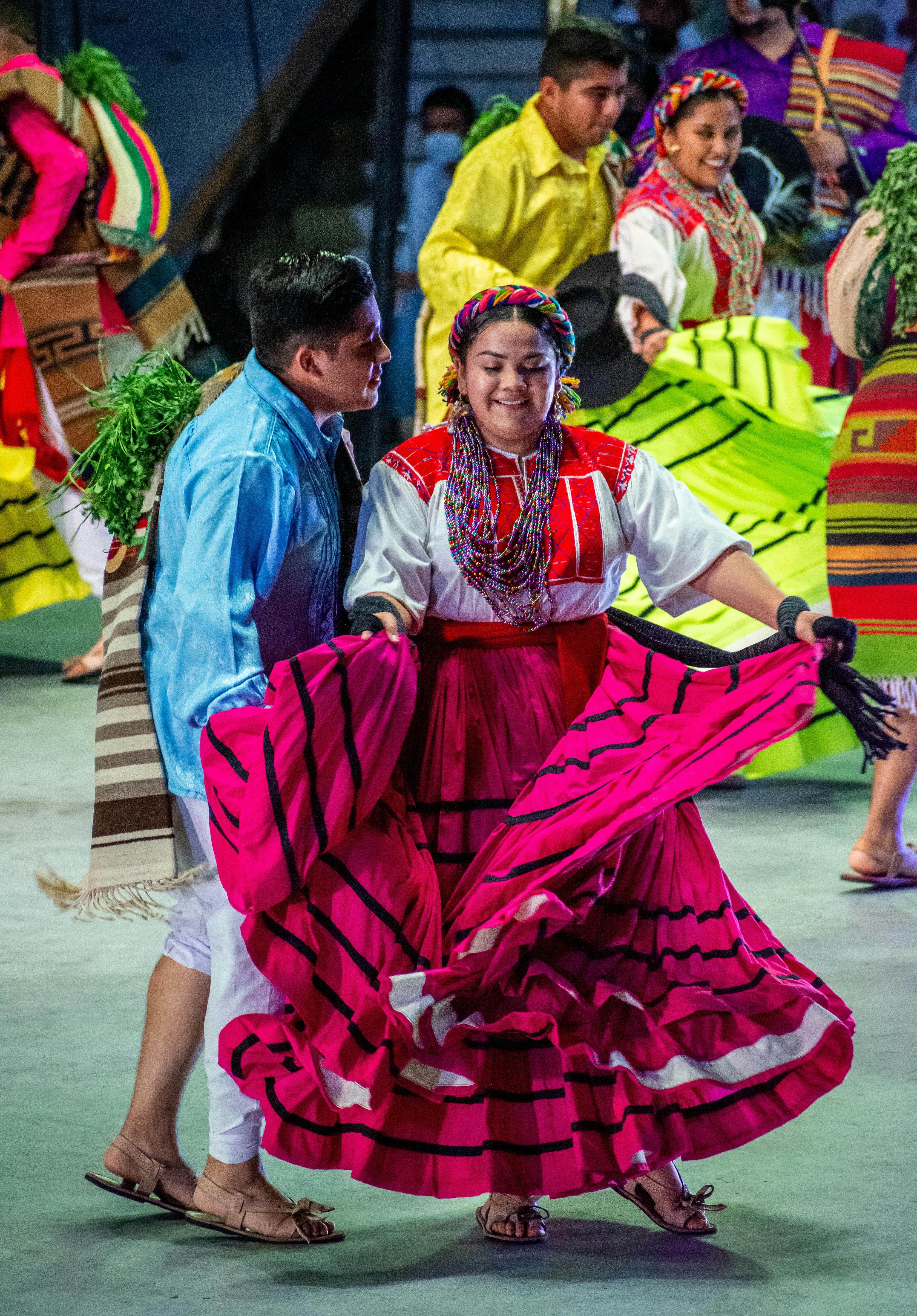 A woman in a colorful dress dancing with other people · Free Stock Photo