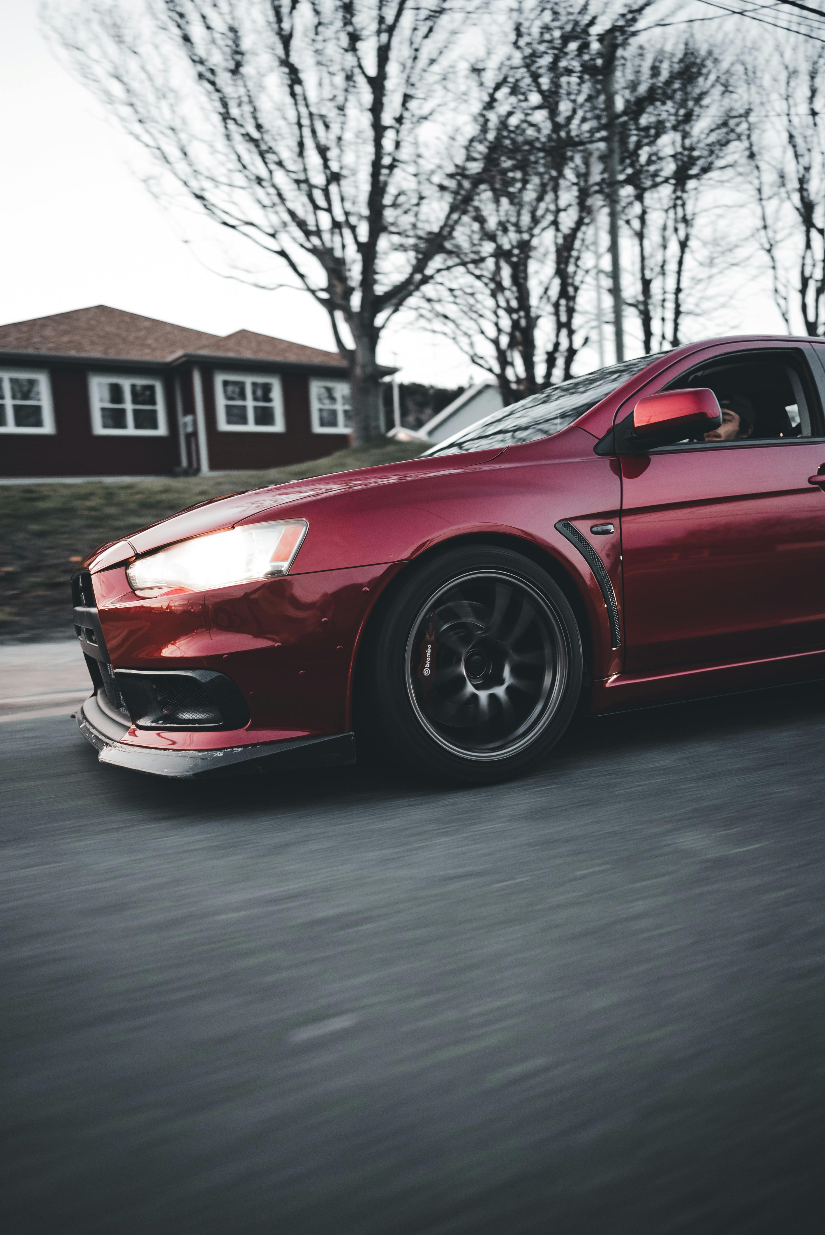 Red Mitsubishi Lancer Evolution Running on Road · Free Stock Photo