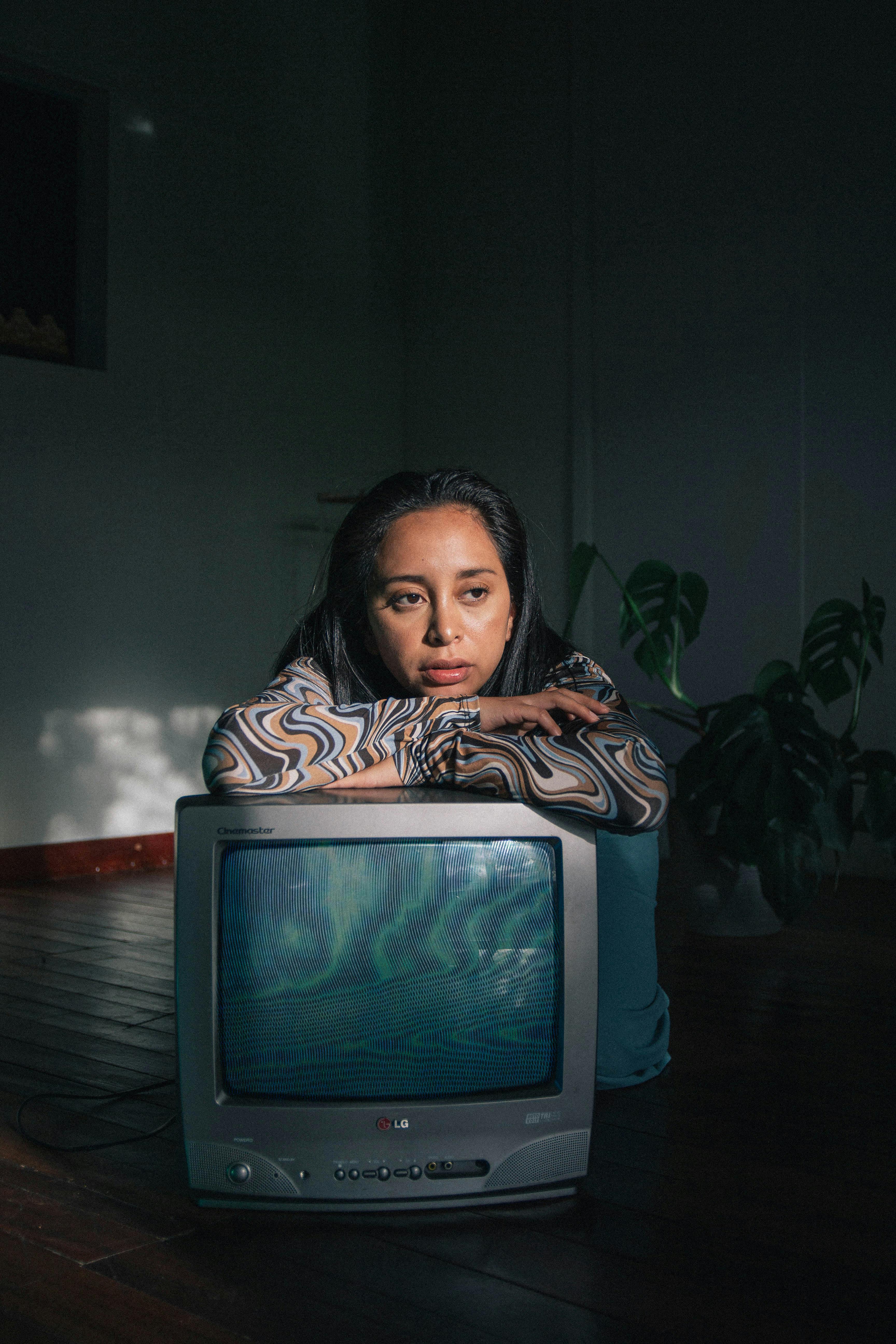 Woman Bending Her Body in Front of Turned-off Television and Fan · Free ...