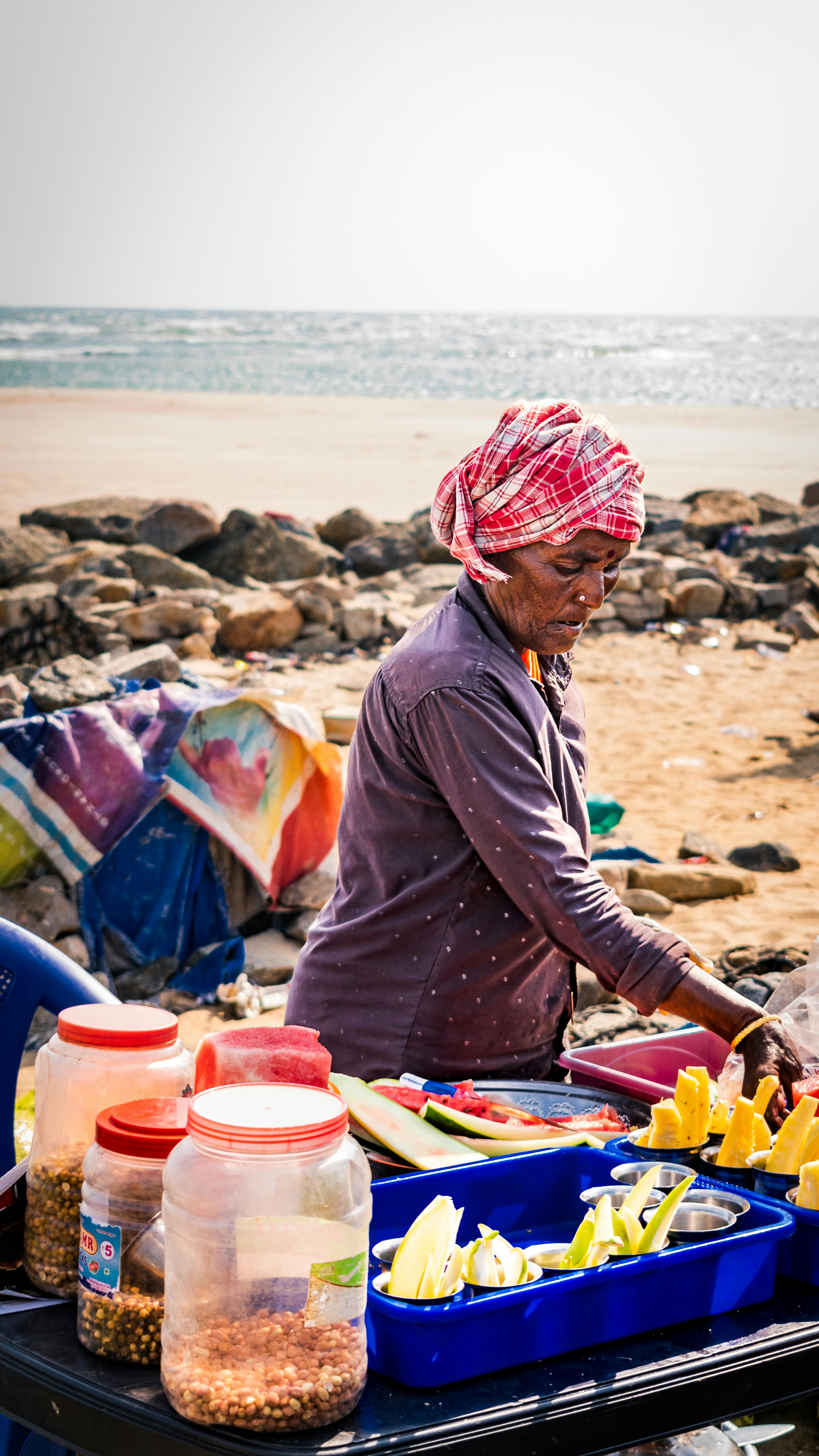 Worker Wearing Asian Conical Hat Sorting Fish on Beach · Free Stock Photo