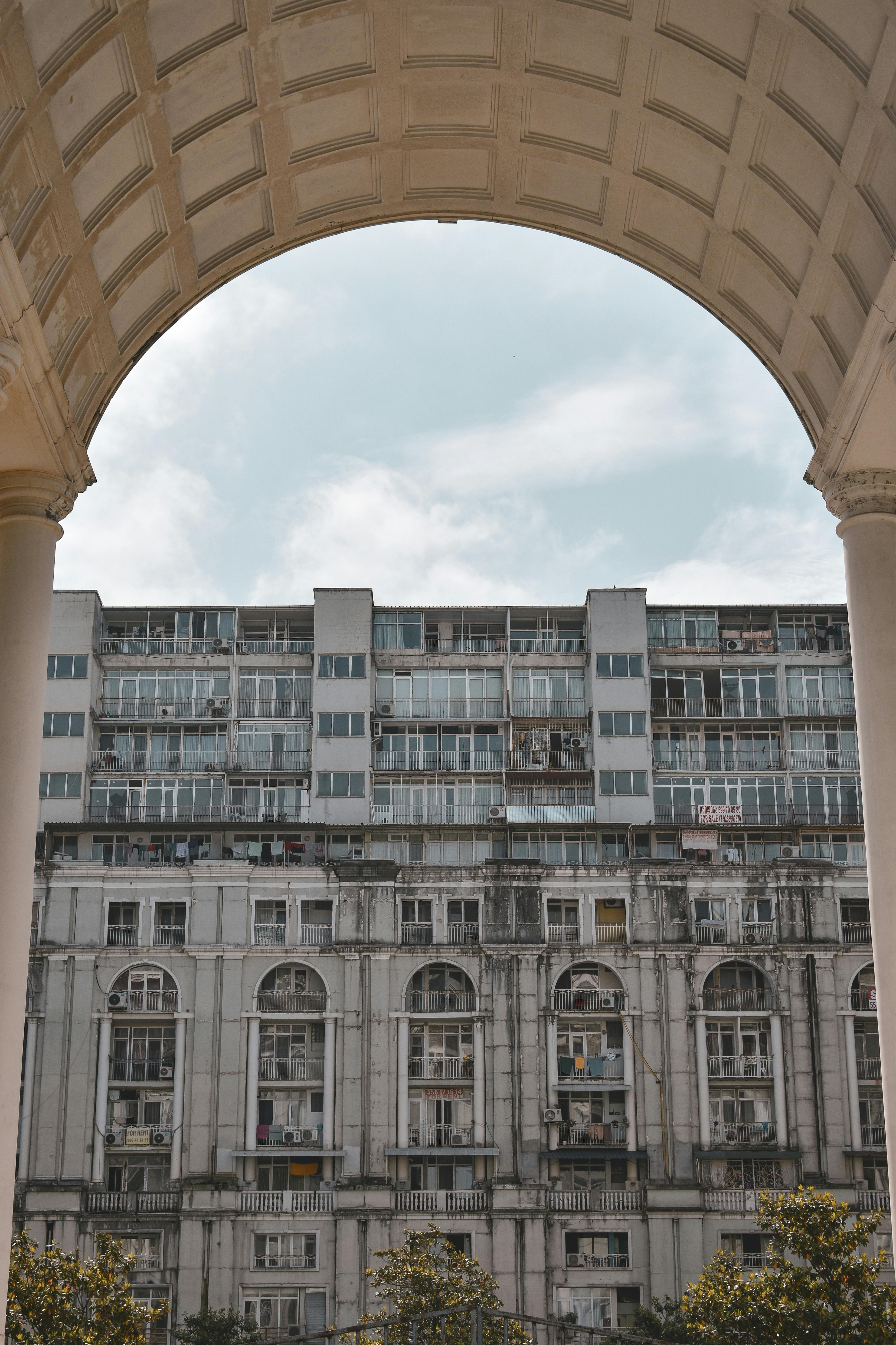 Old Residential Building Seen through Arch · Free Stock Photo