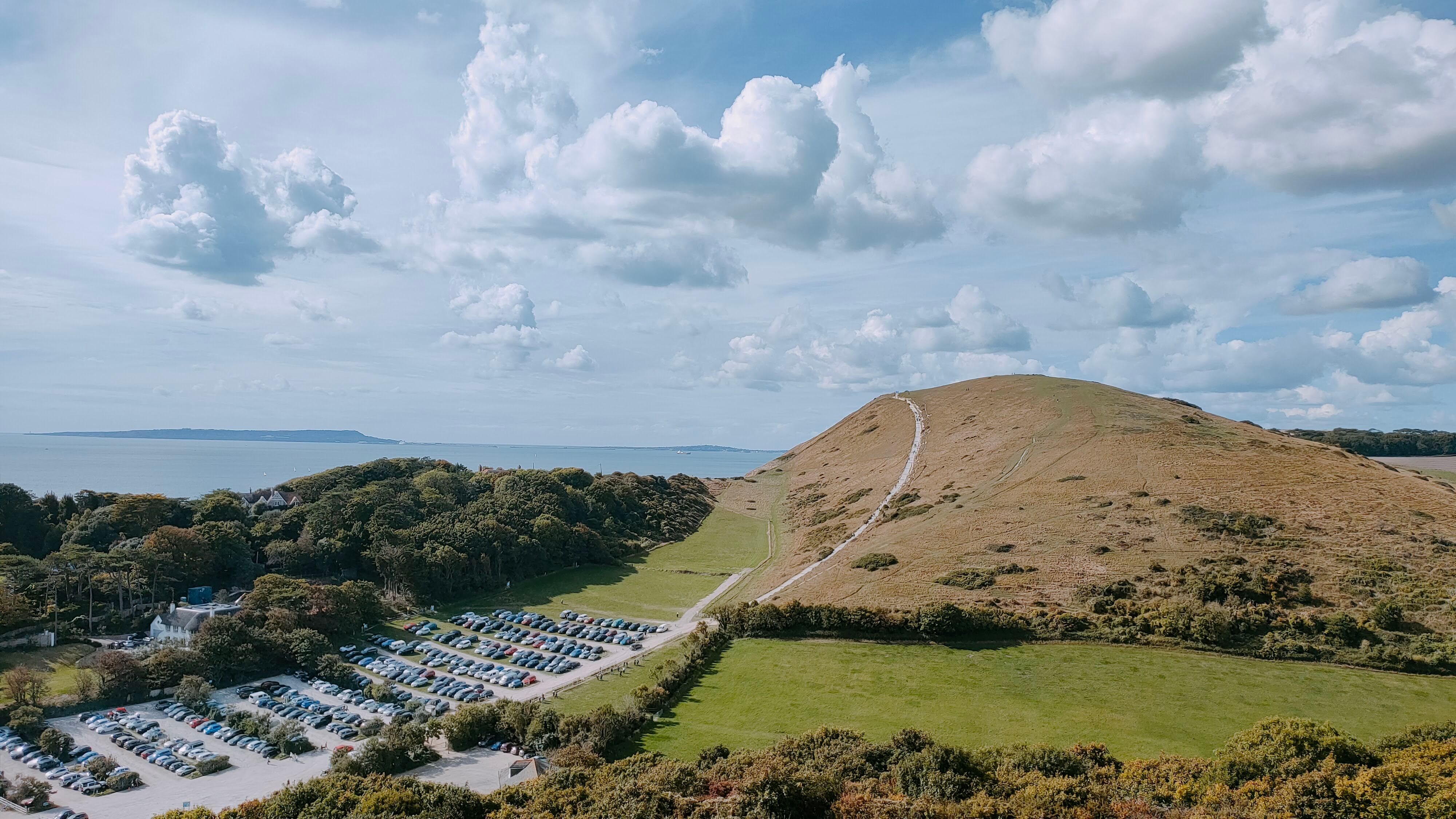 Scenic Landscape with a Hill against a Cloudy Sky · Free Stock Photo