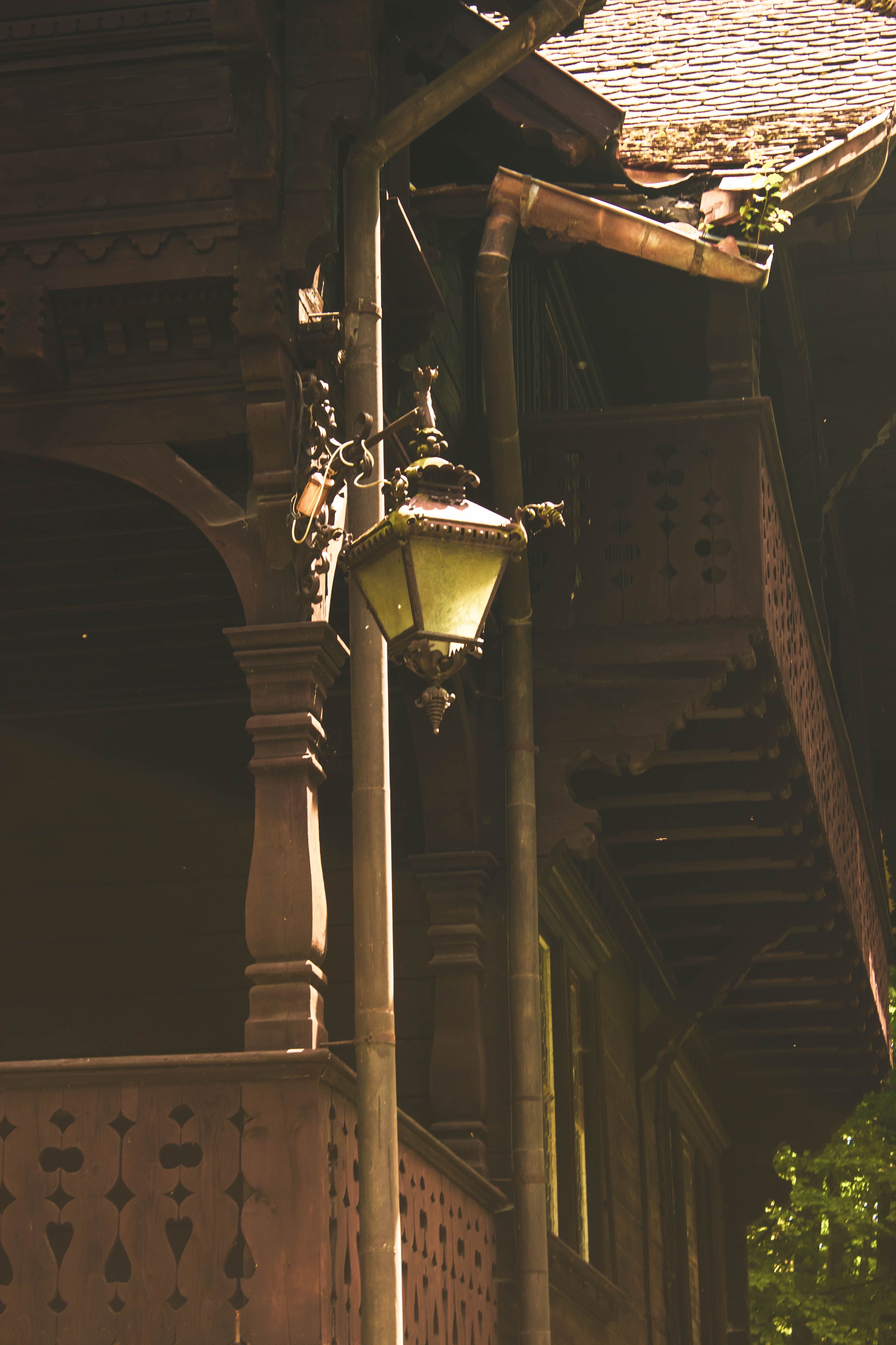 Lantern Hanged on Drainpipe on Building Corner · Free Stock Photo
