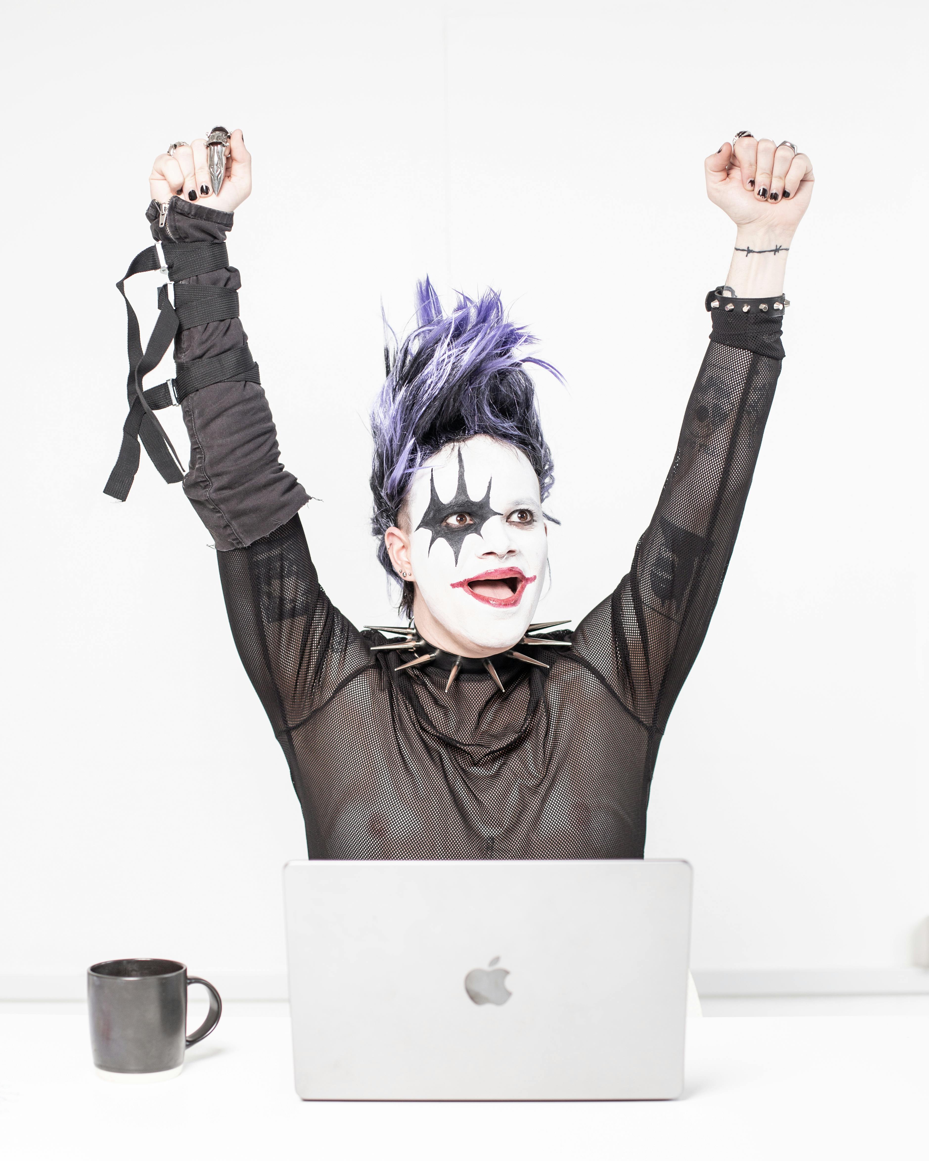 Man in Goth Style Clothes and Makeup Sitting in front of a Laptop and ...