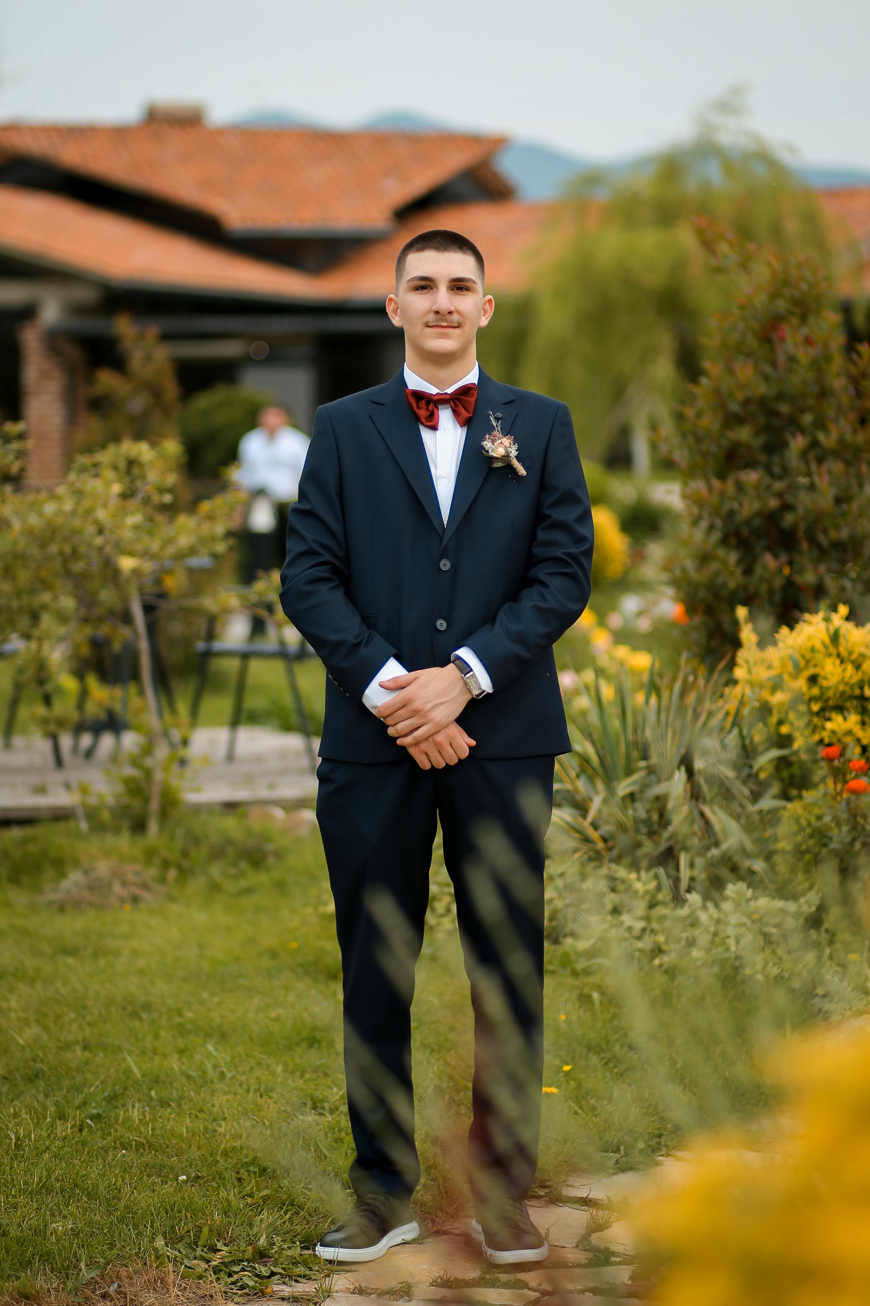 Elegant Young Man in a Suit with a Bow Tie Standing in the Garden ...