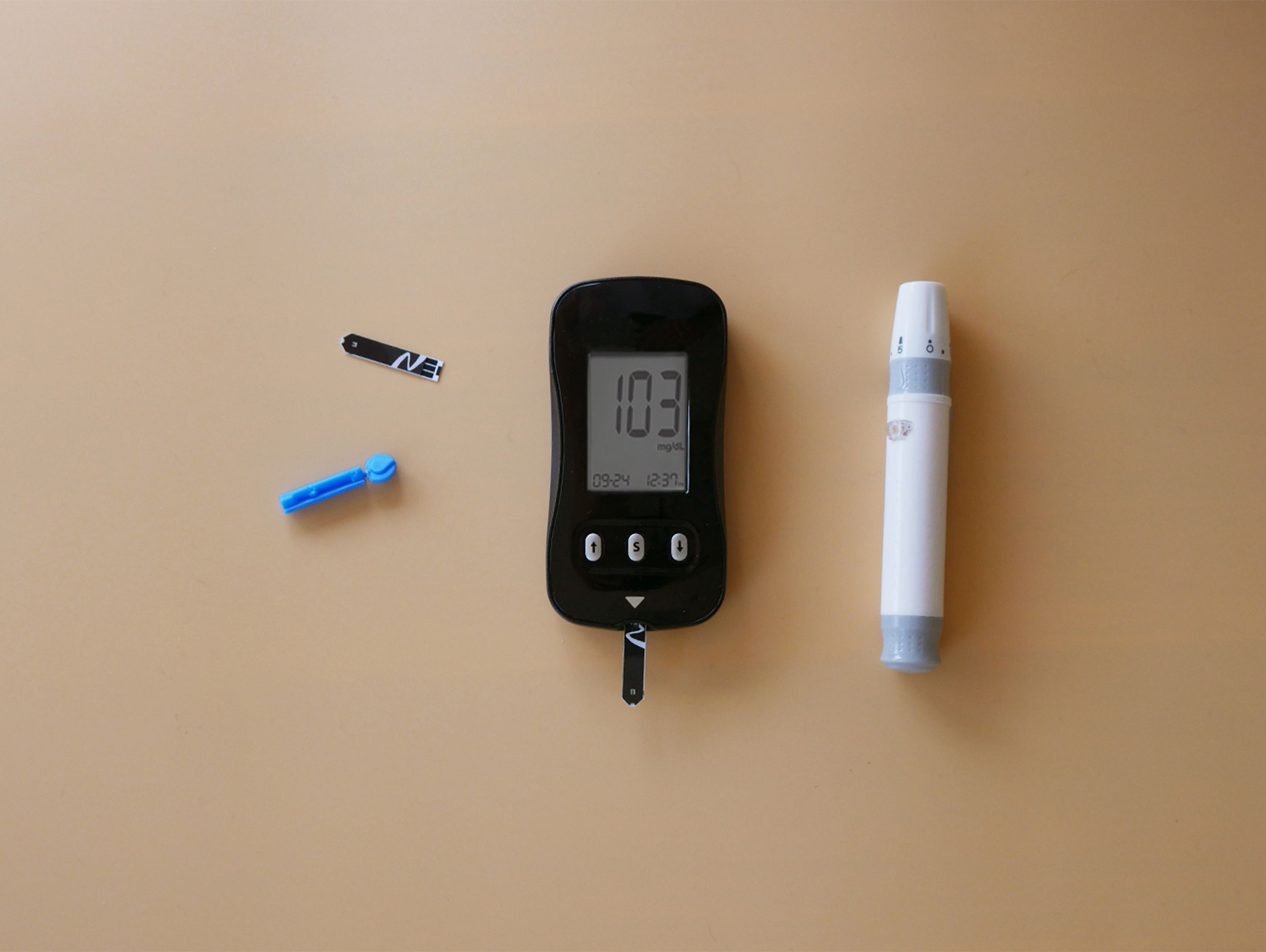 A blood glucose meter and a pen on a table · Free Stock Photo