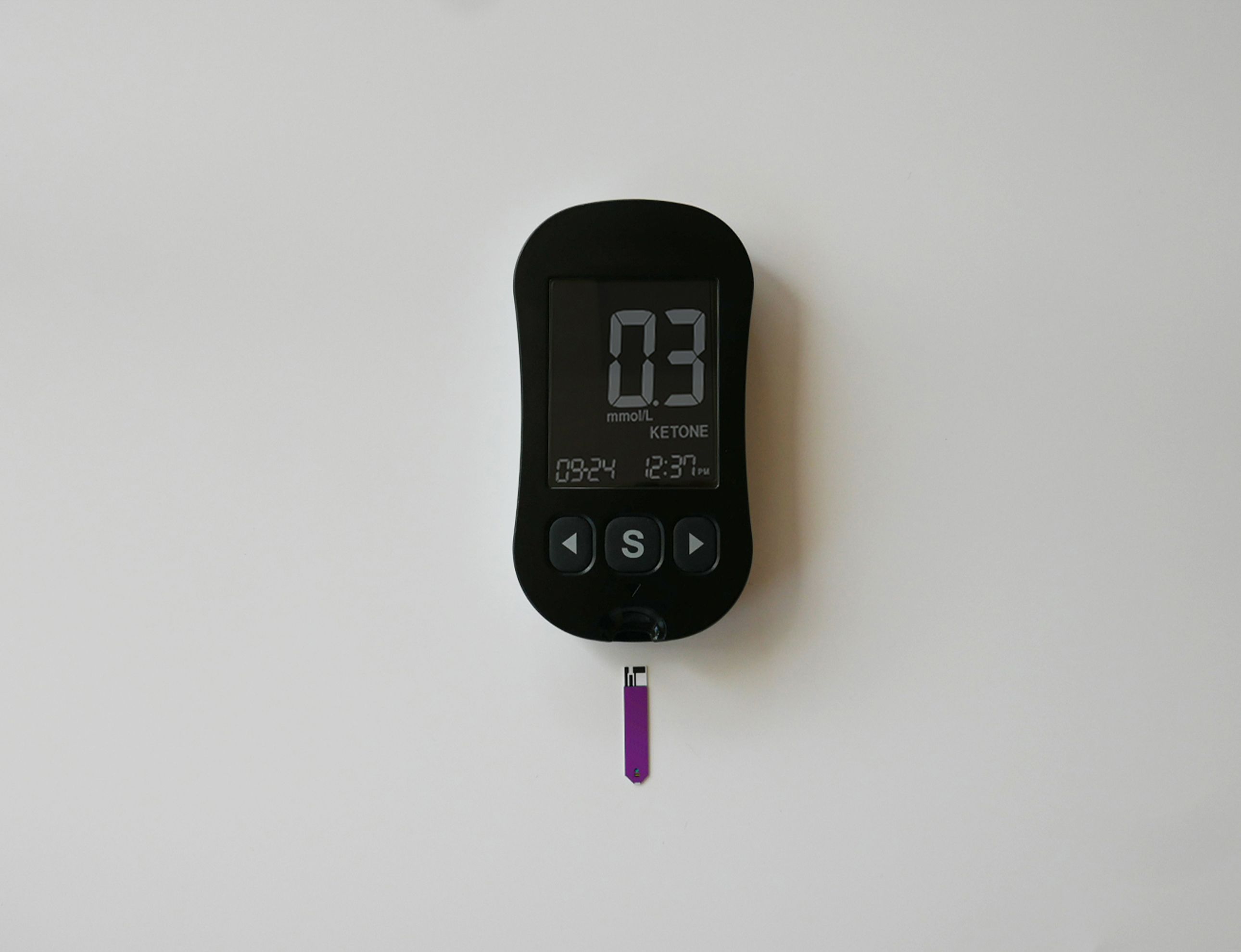 A digital blood glucose meter on a white background · Free Stock Photo