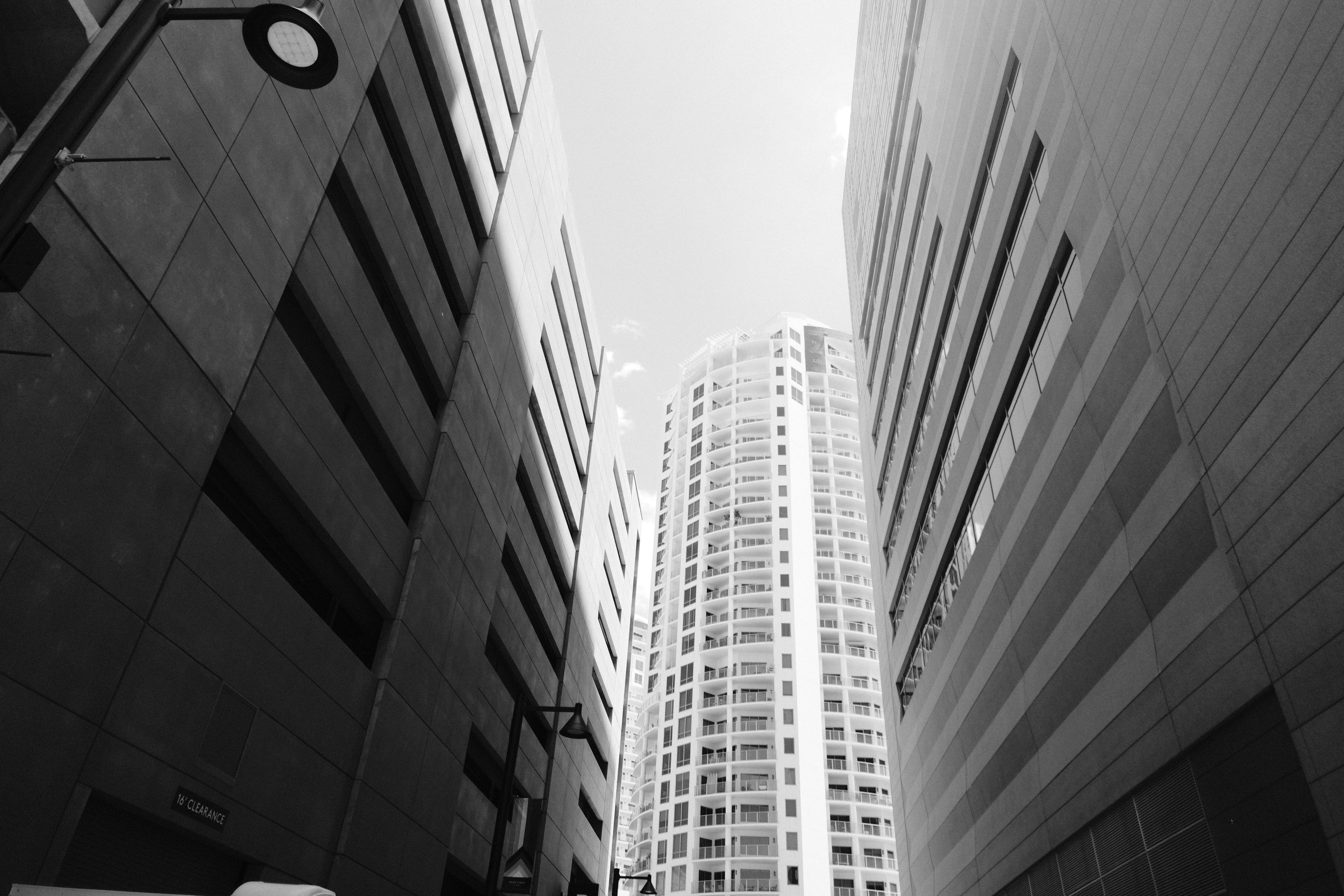 Residential Skyscraper behind Buildings Wall · Free Stock Photo