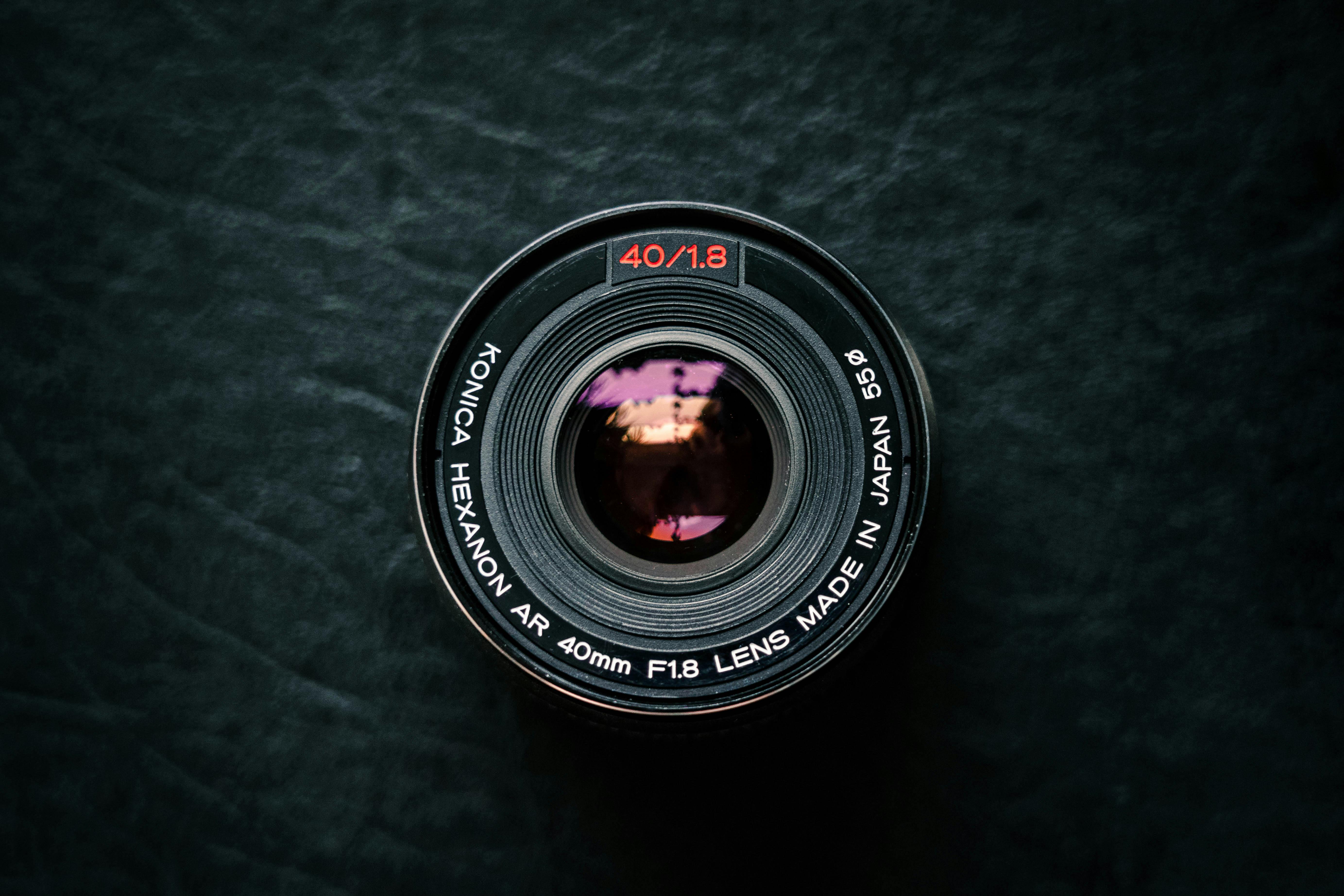 Camera Lens On Black Surface · Free Stock Photo