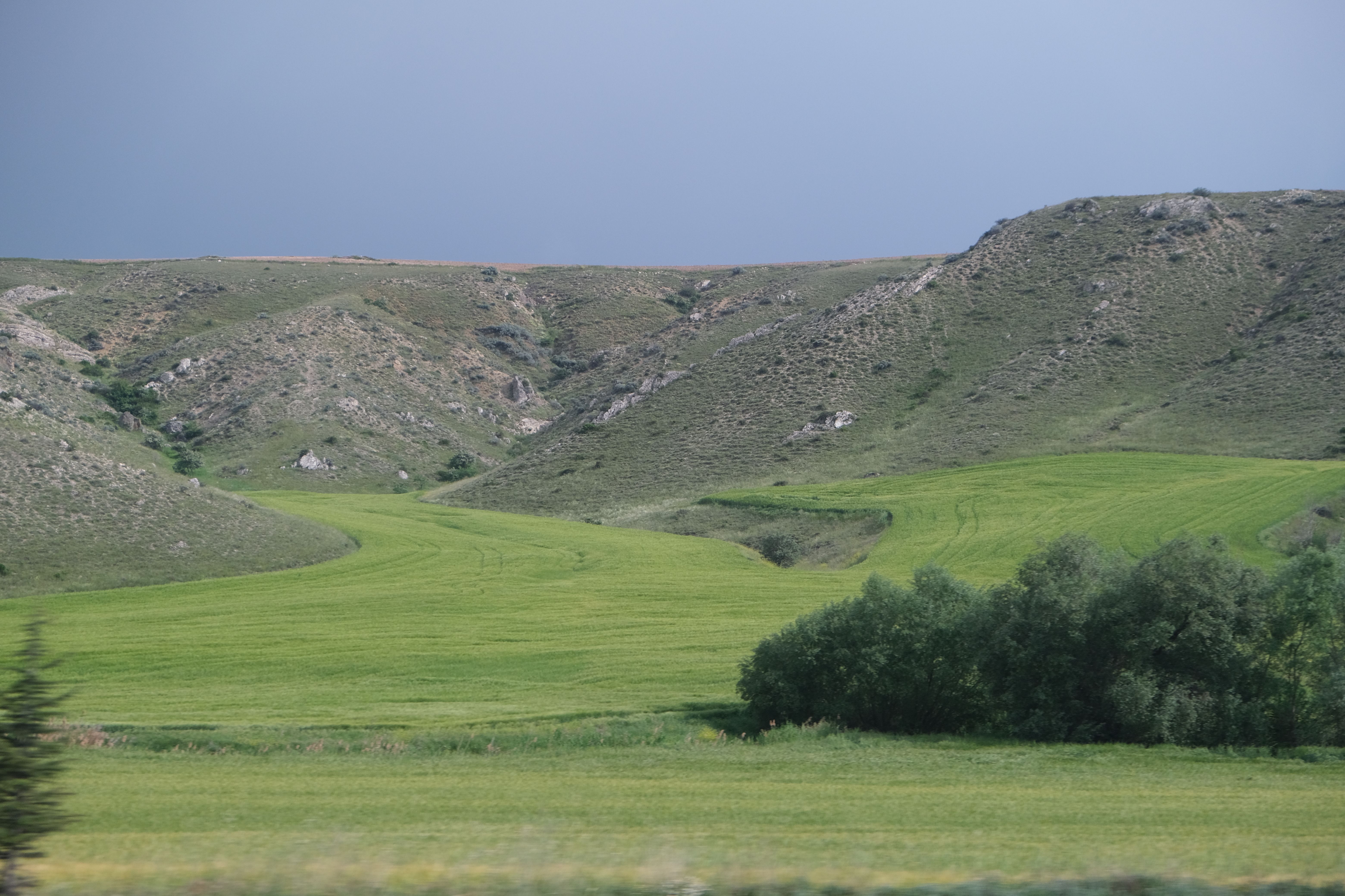 Rural Landscape with Green Fields between Hills · Free Stock Photo