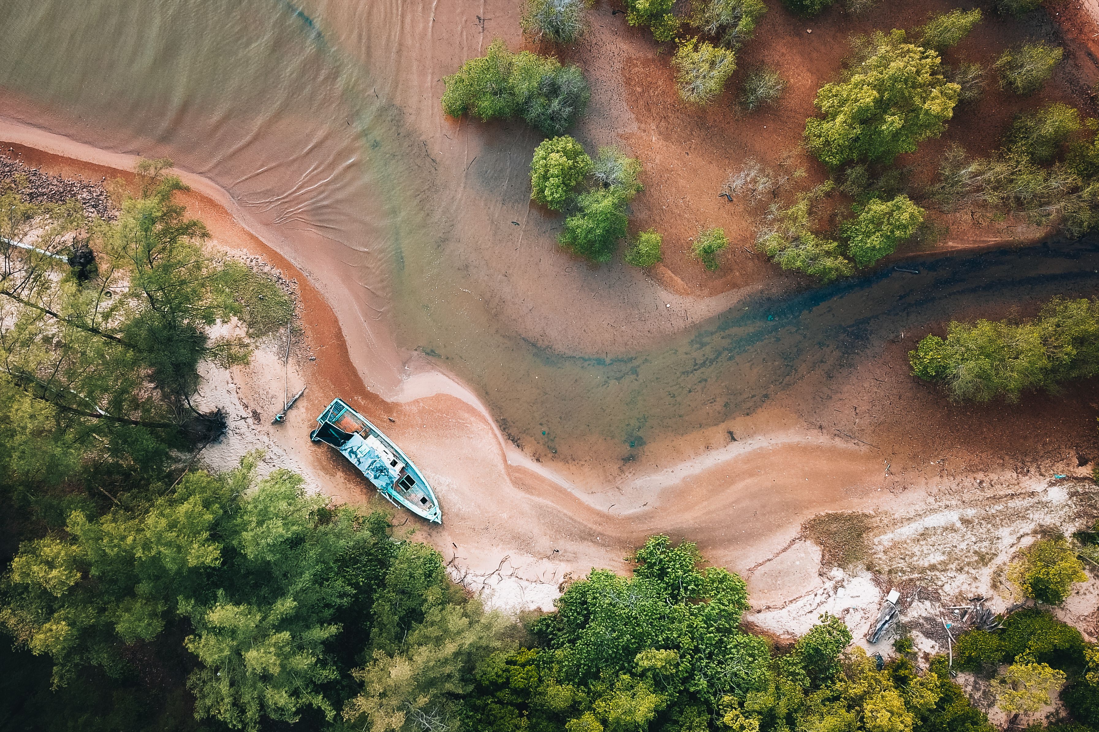 Top View of a Boat on the Beach near a Shallow River · Free Stock Photo