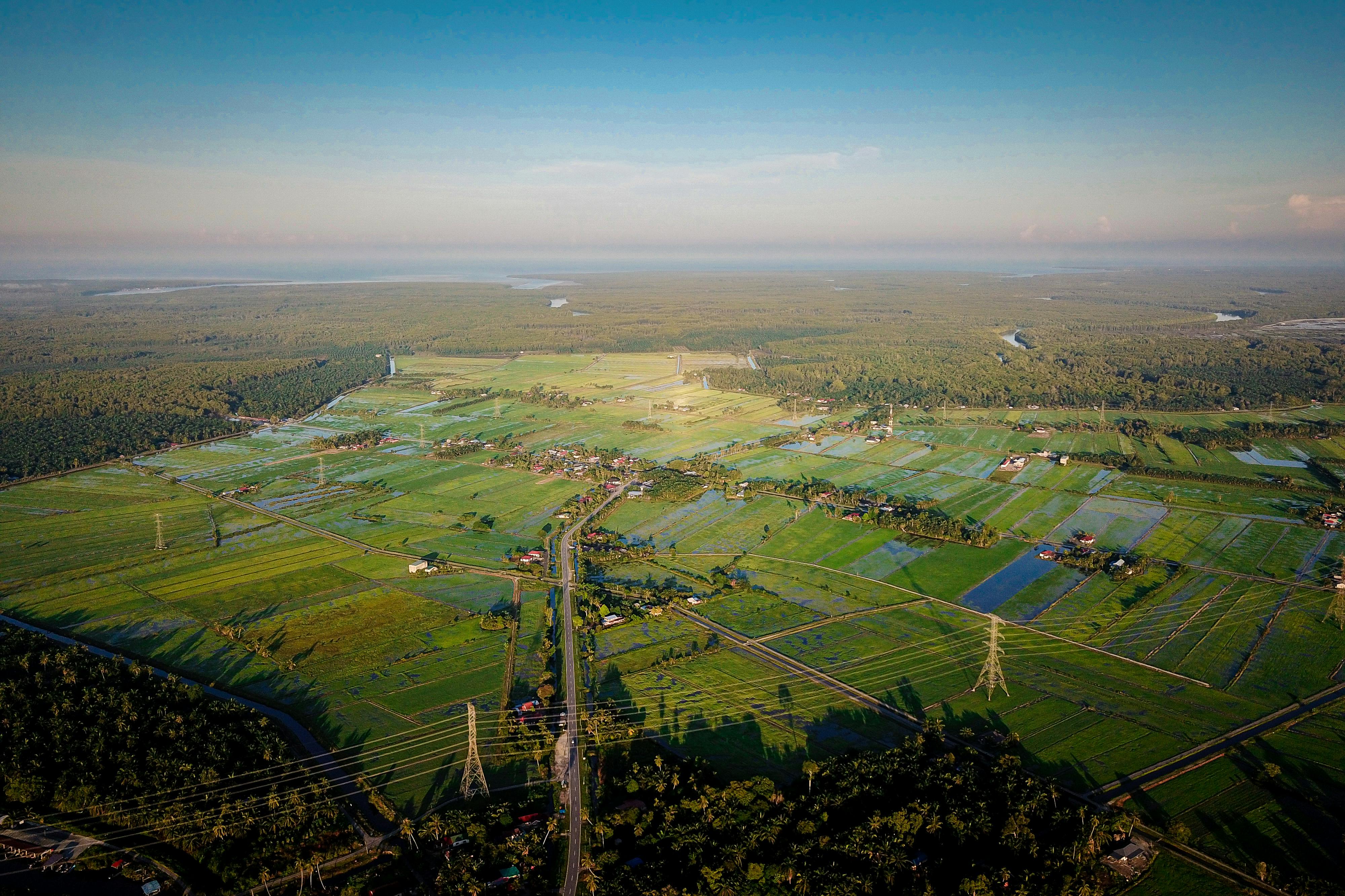 Aerial View of Cropland and Seascape in Distance · Free Stock Photo