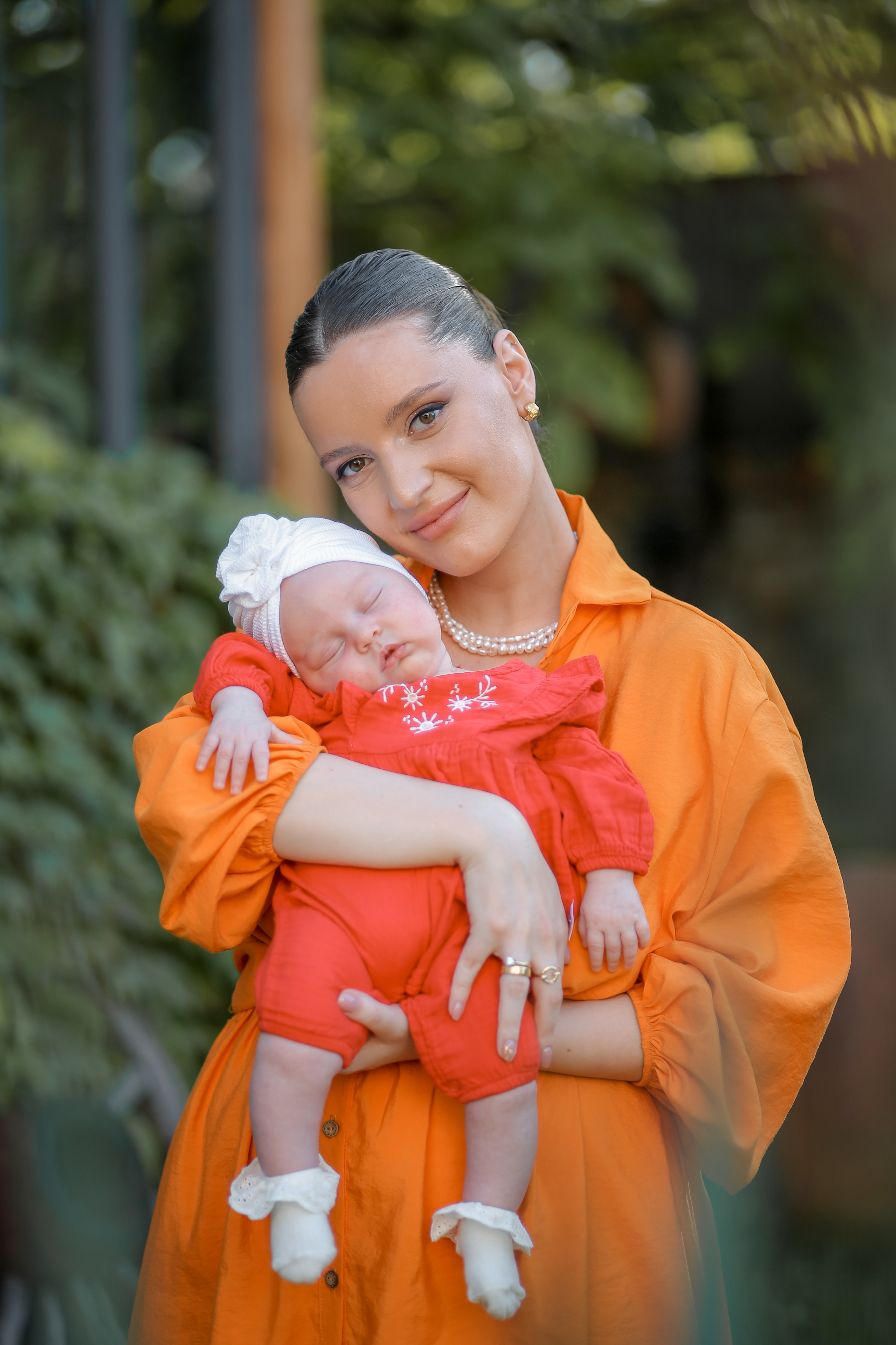 Young Woman in an Orange Dress Holding Her Newborn Baby · Free Stock Photo