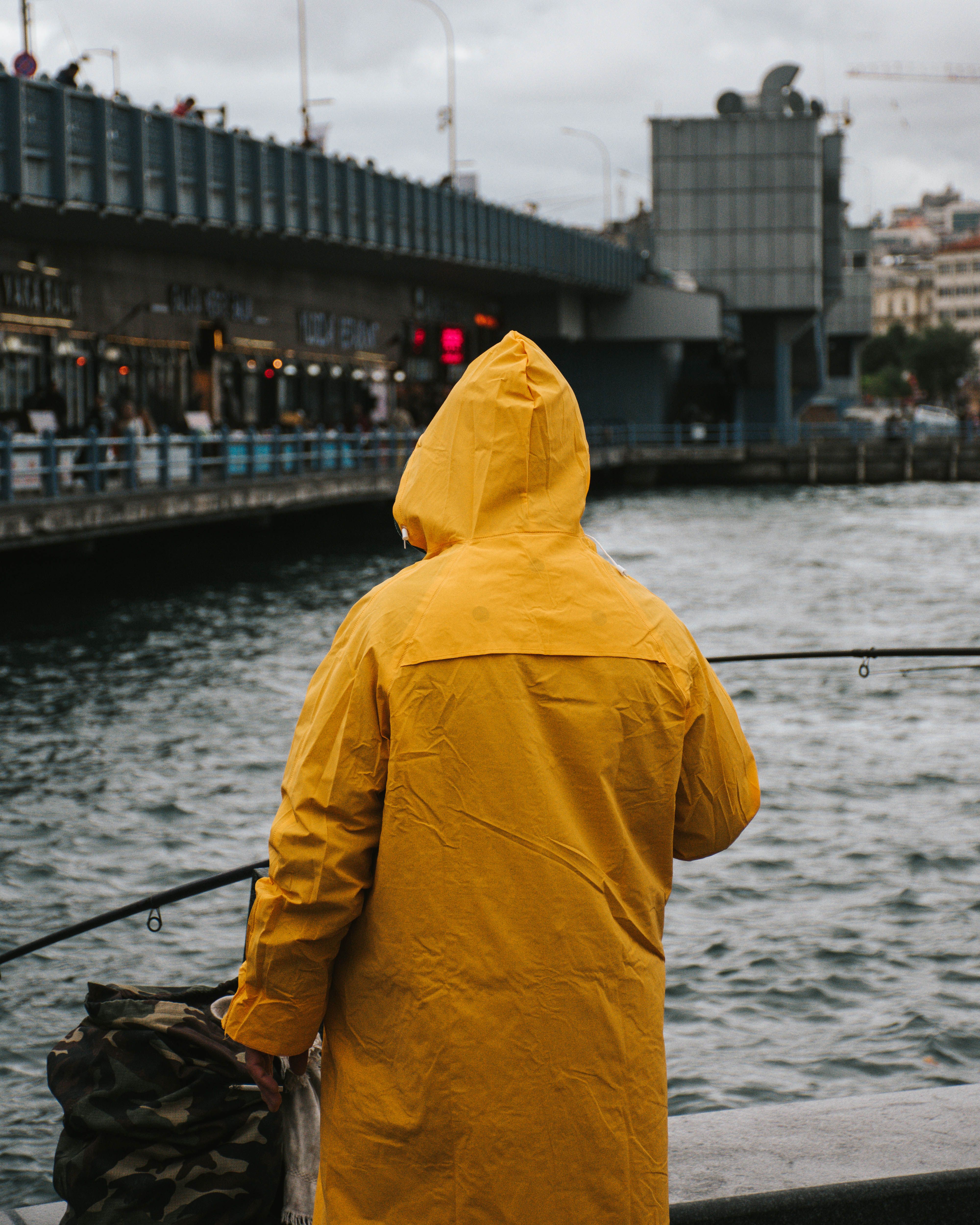 Fisherman in Raincoat on Shore in Istanbul · Free Stock Photo