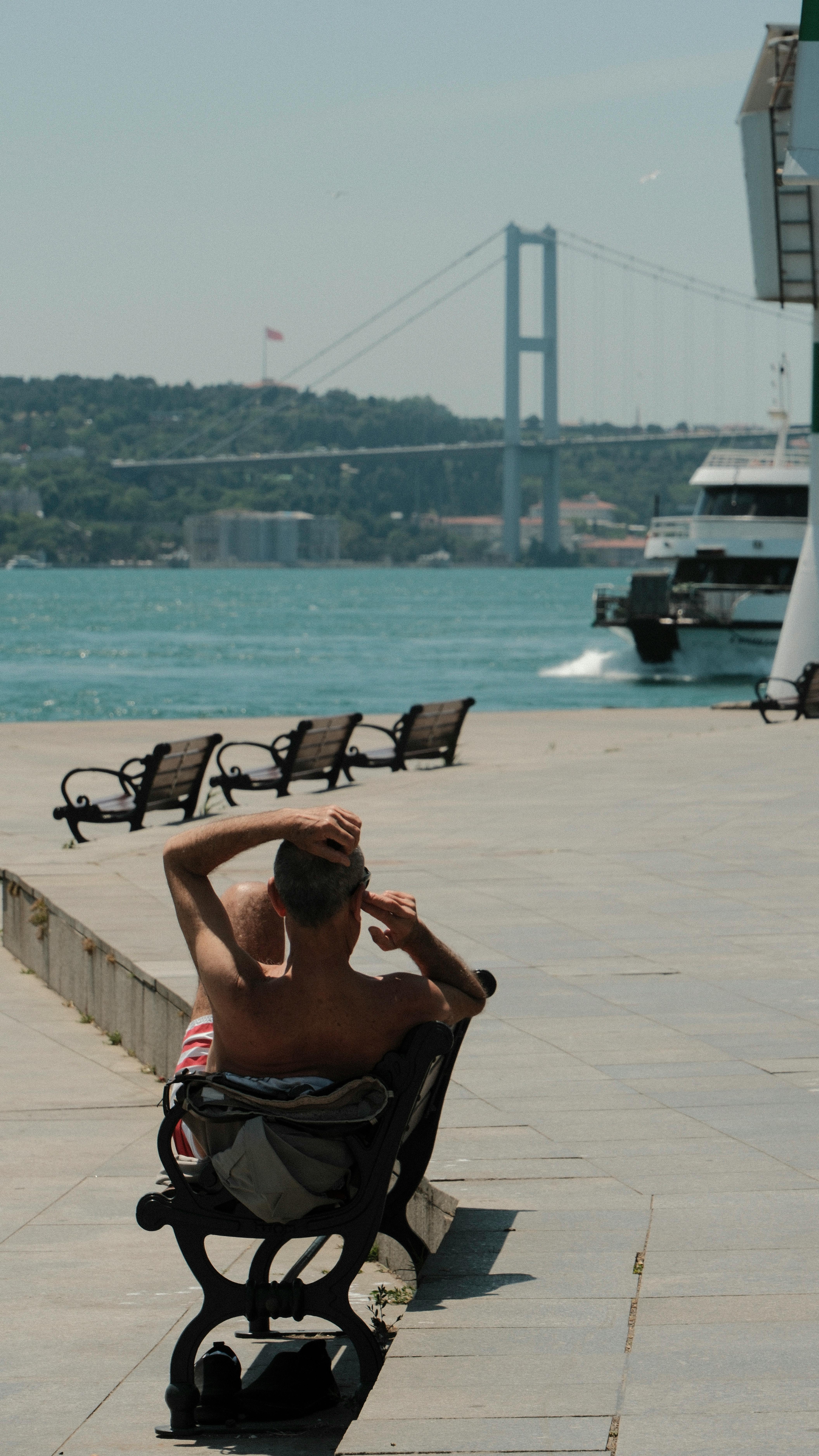 A Man Sunbathing on a Bench on the Shore of the Bosphorus Strait in ...