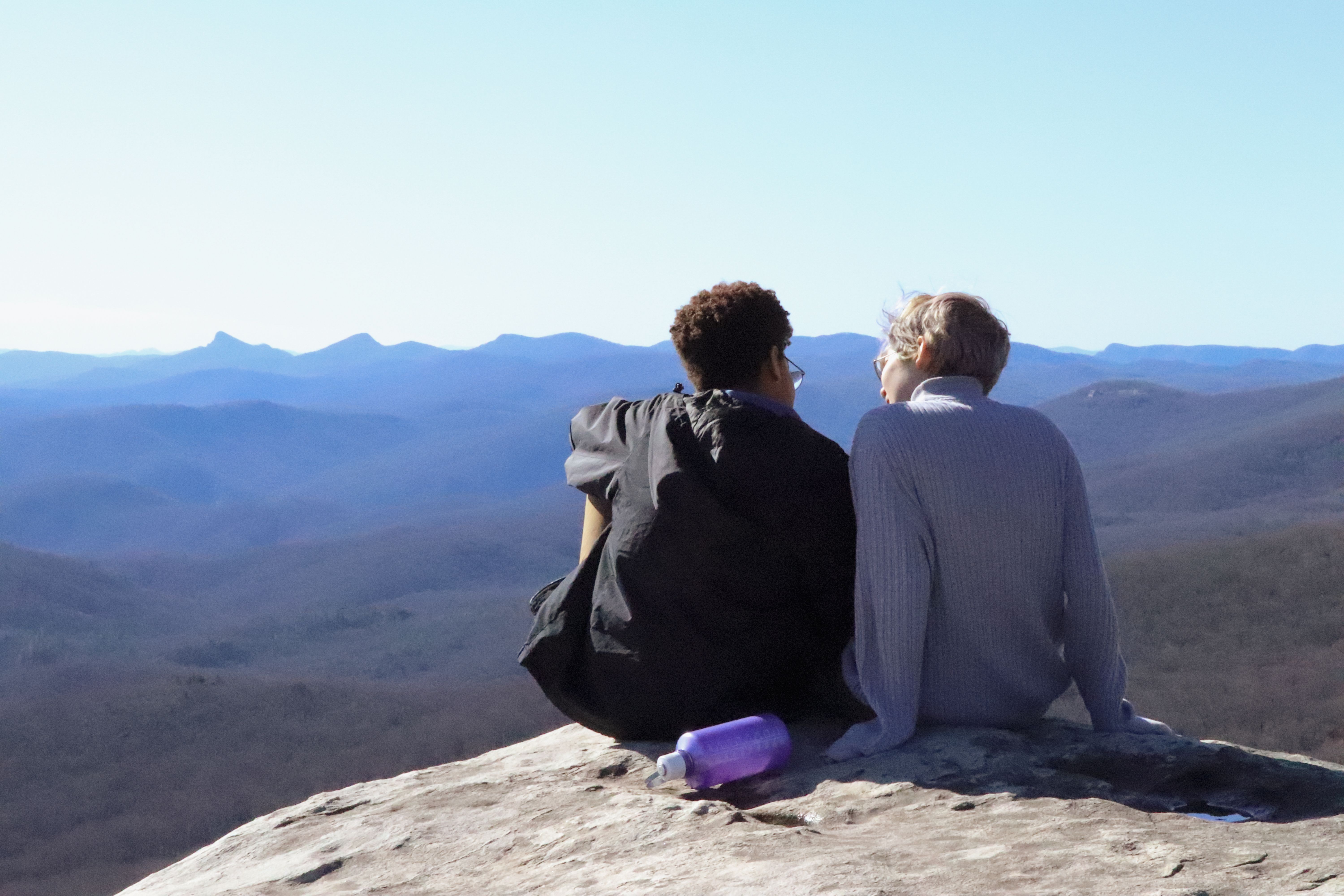 Couple Sit at Viewpoint in Mountains · Free Stock Photo