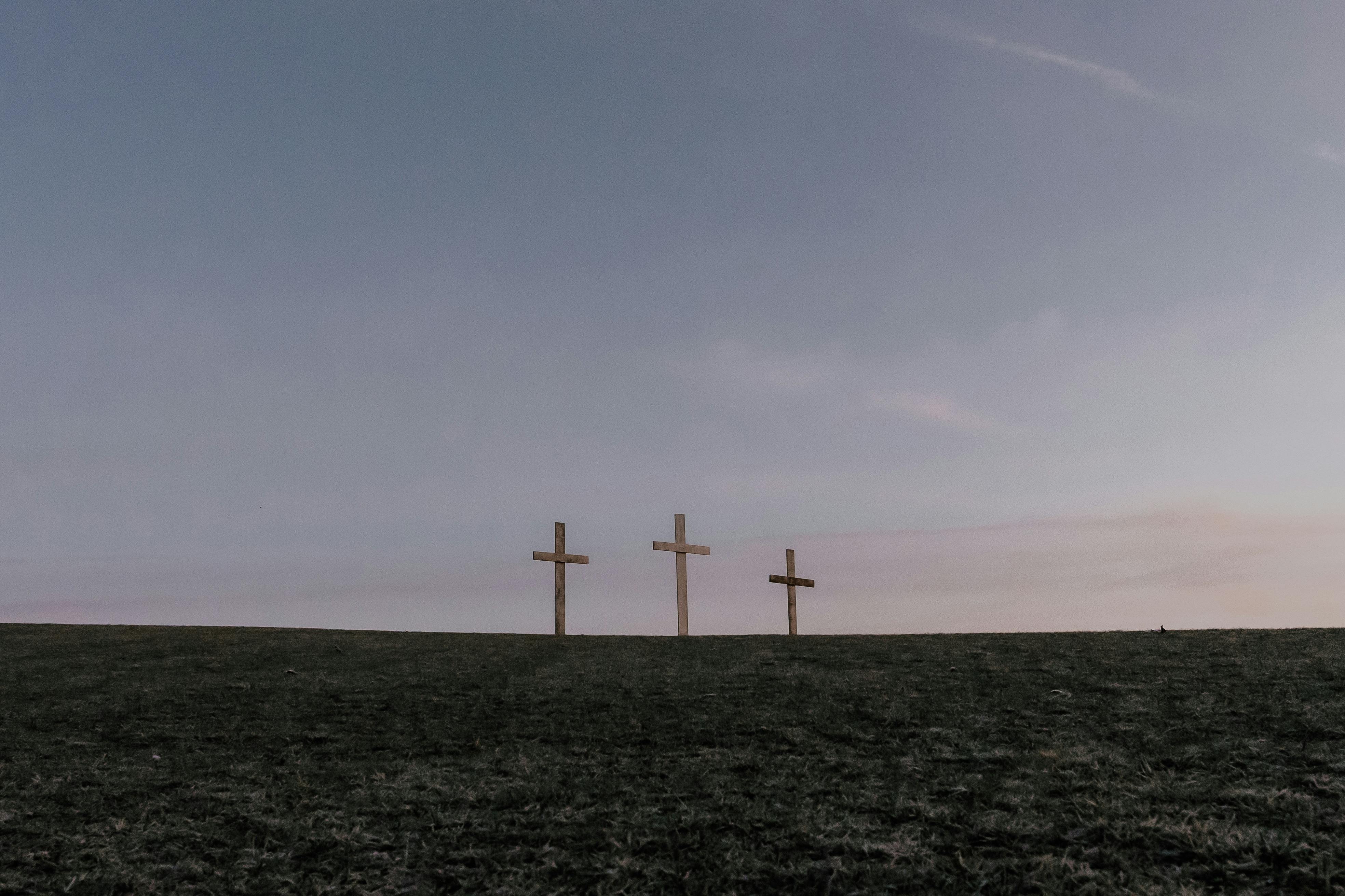 Three Crosses on a Field at Sunset · Free Stock Photo