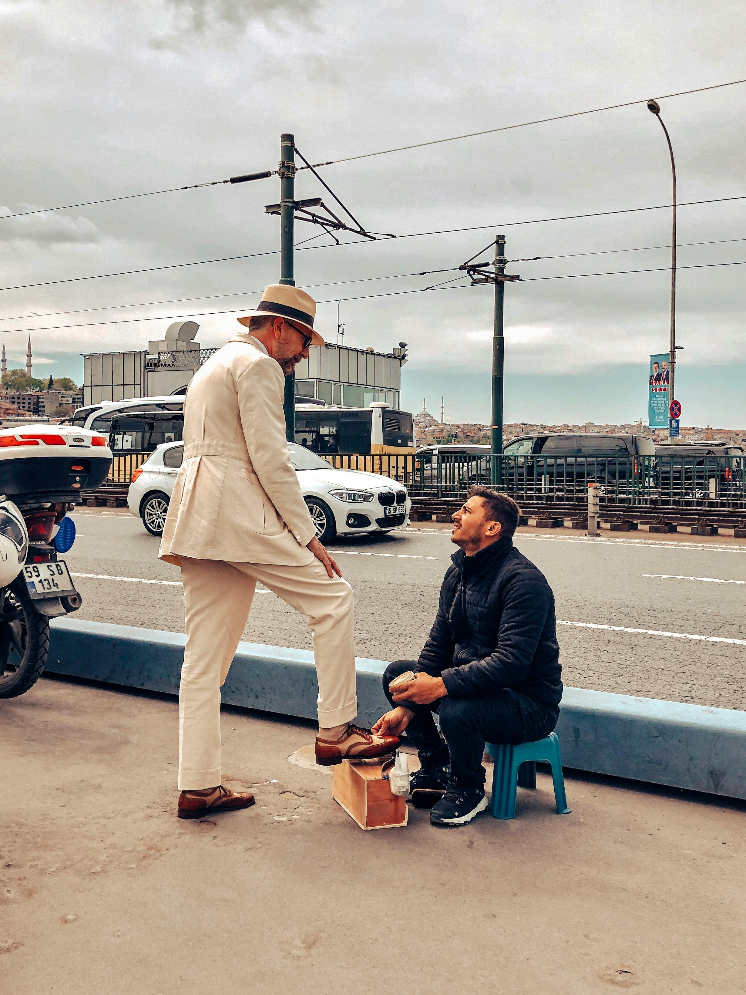 Man in a Suit Getting His Shoes Cleaned by a Shoe Cleaner on the Street ...