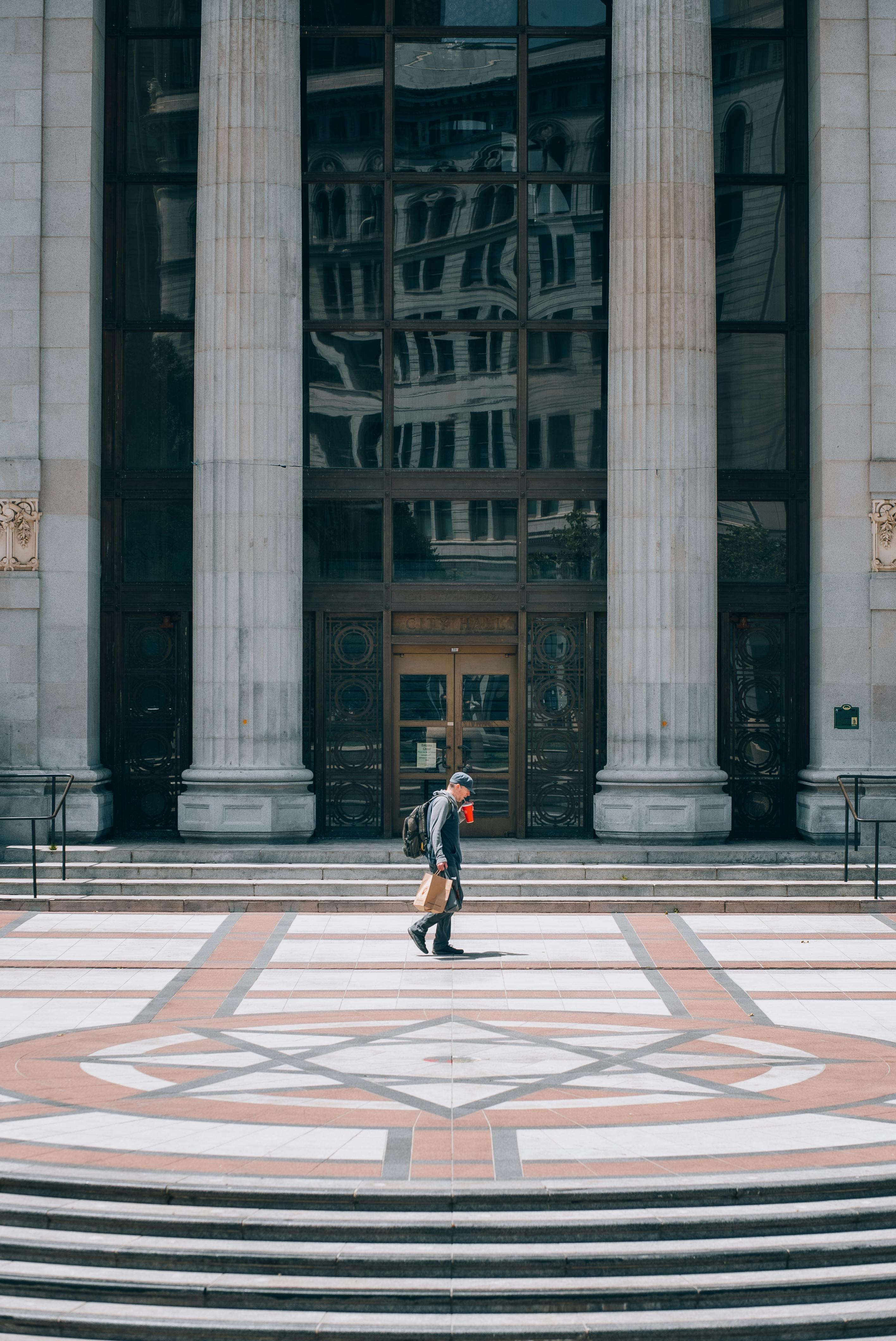 Person Walking near Building Columns · Free Stock Photo