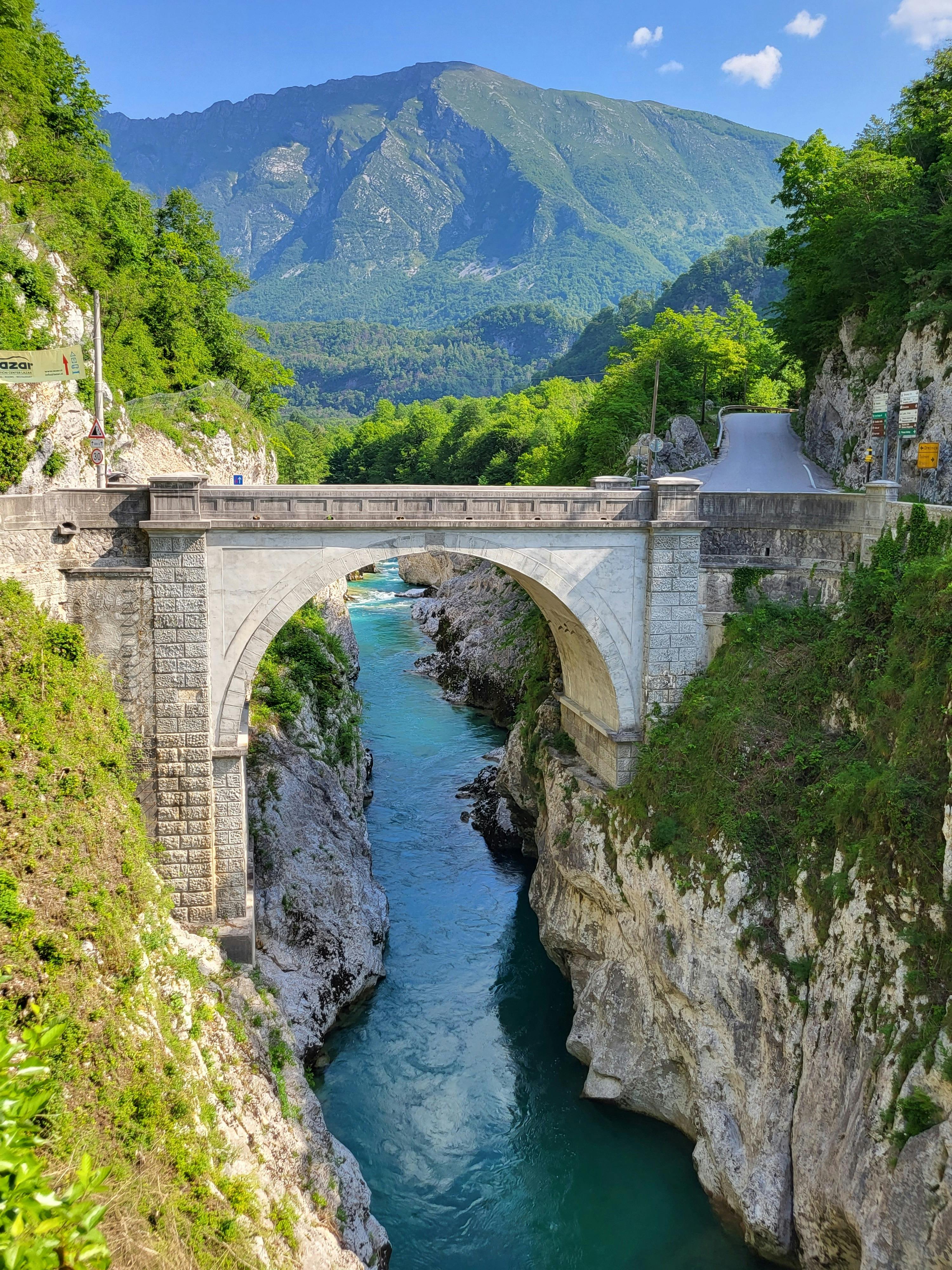 Concrete Bridge over Clear Blue River Beside Mountain · Free Stock Photo