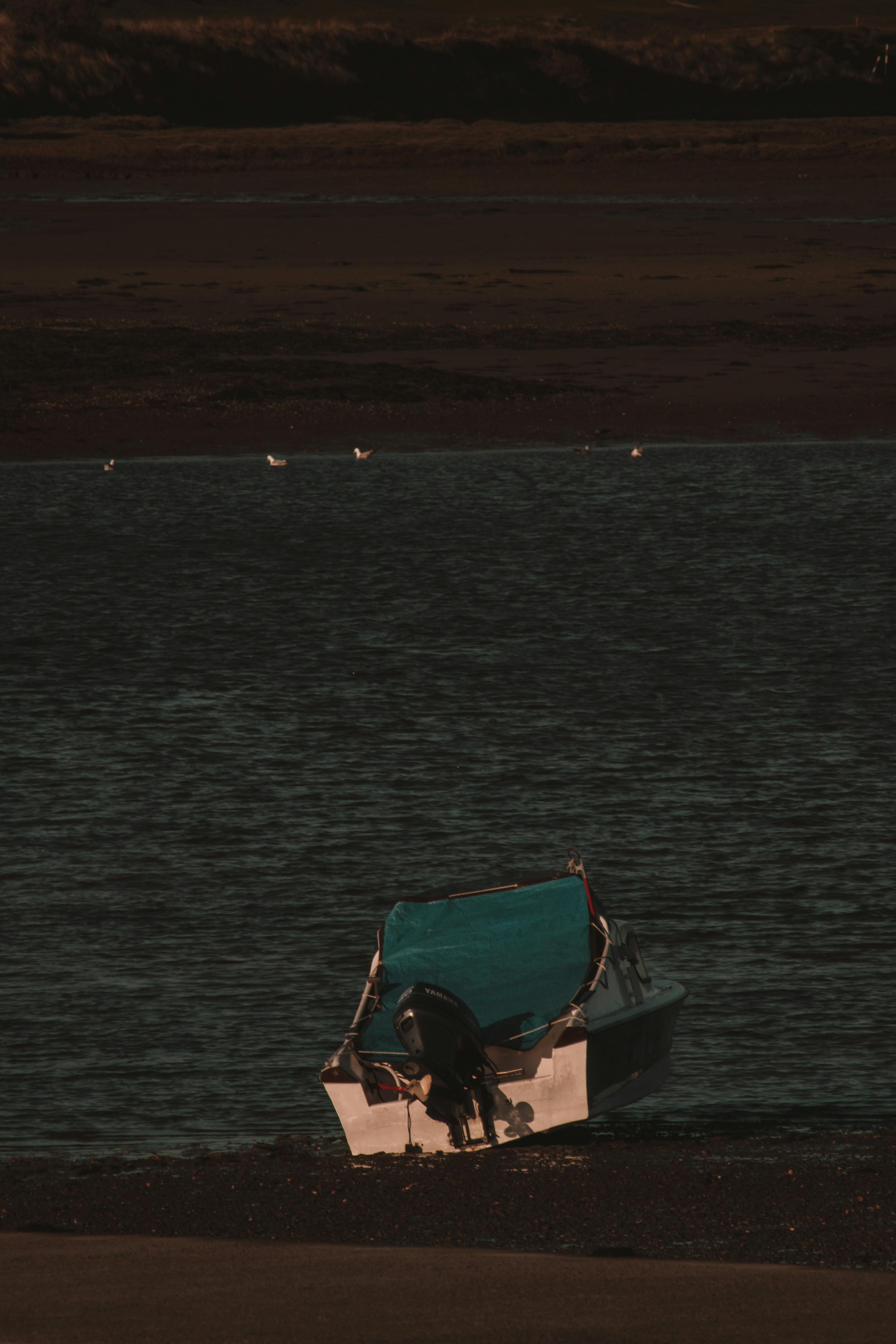 A Boat Swimming on a Sea in Dark · Free Stock Photo