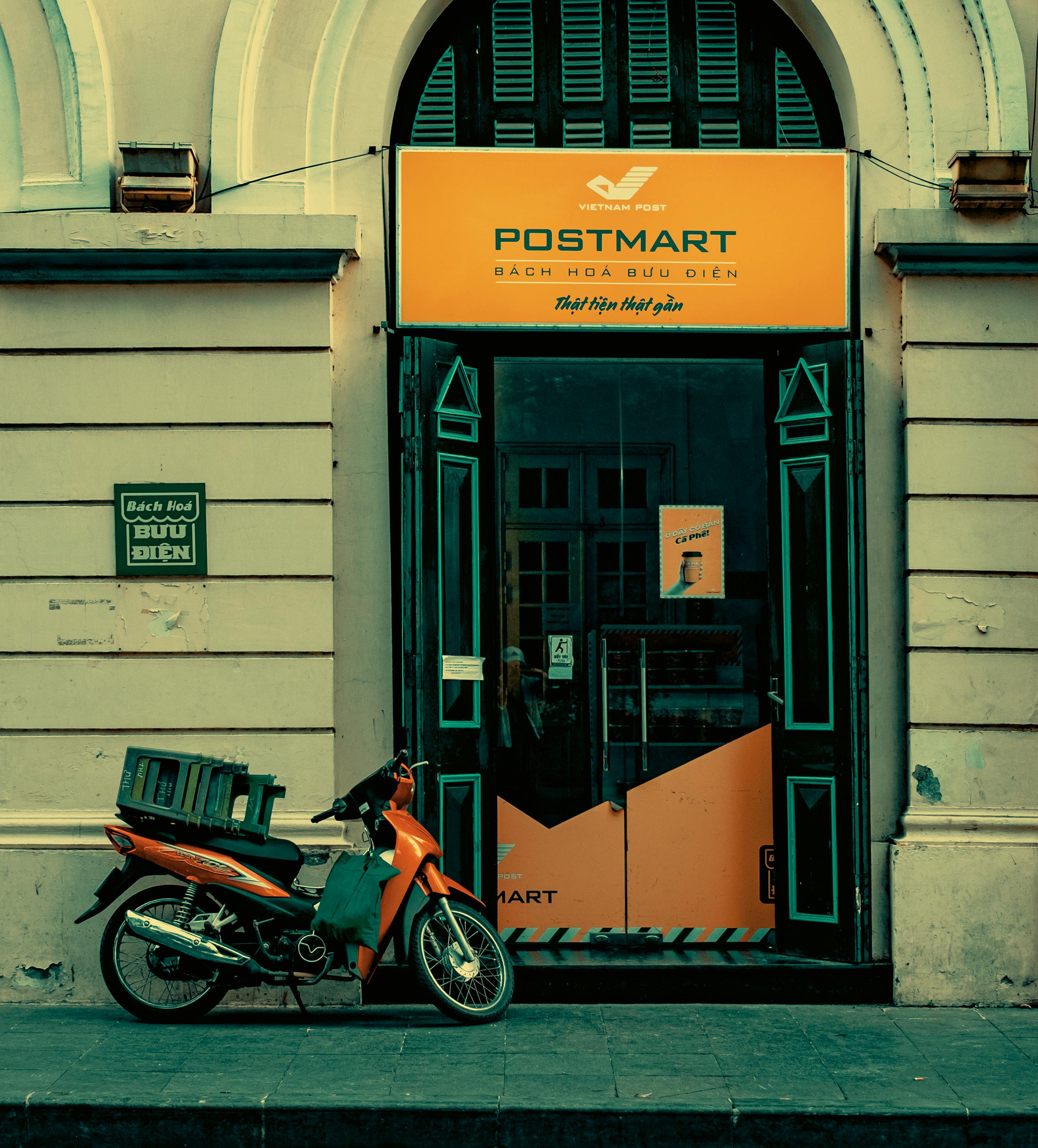 A Motor Scooter Parked in front of the Entrance to a Vietnamese Post ...
