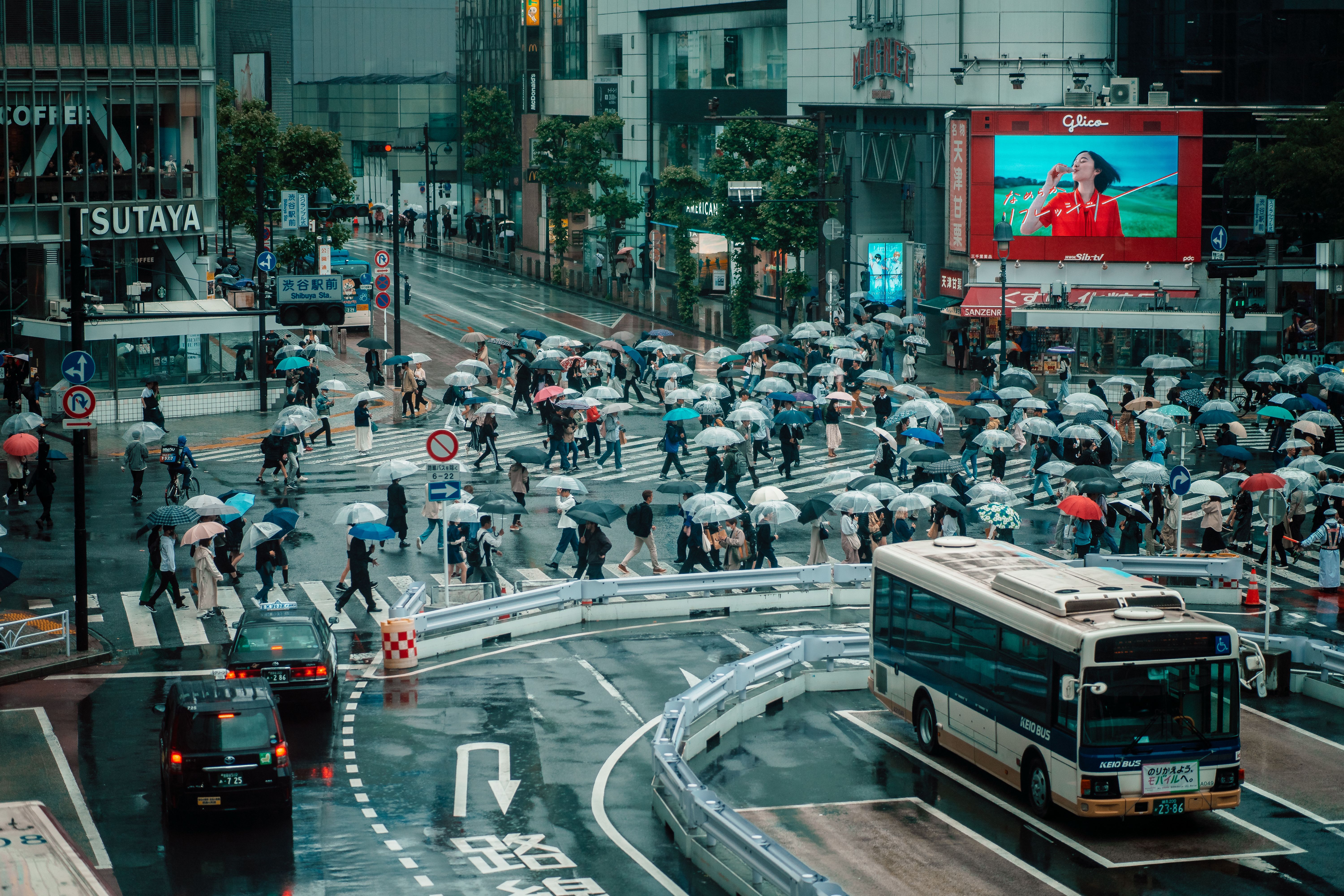 A busy city street with people walking and cars · Free Stock Photo