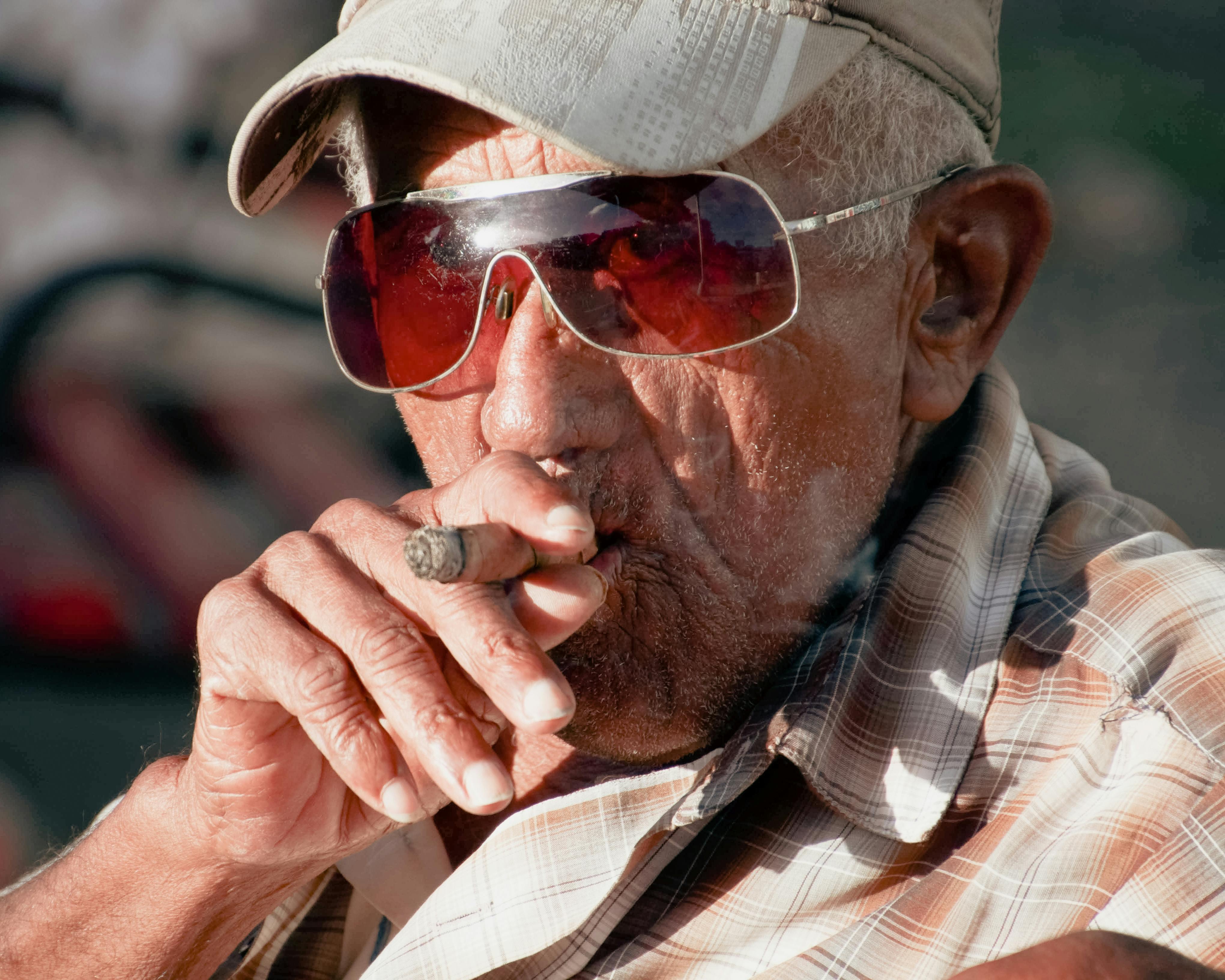 Close-up of an Elderly Man Smoking a Cigar · Free Stock Photo