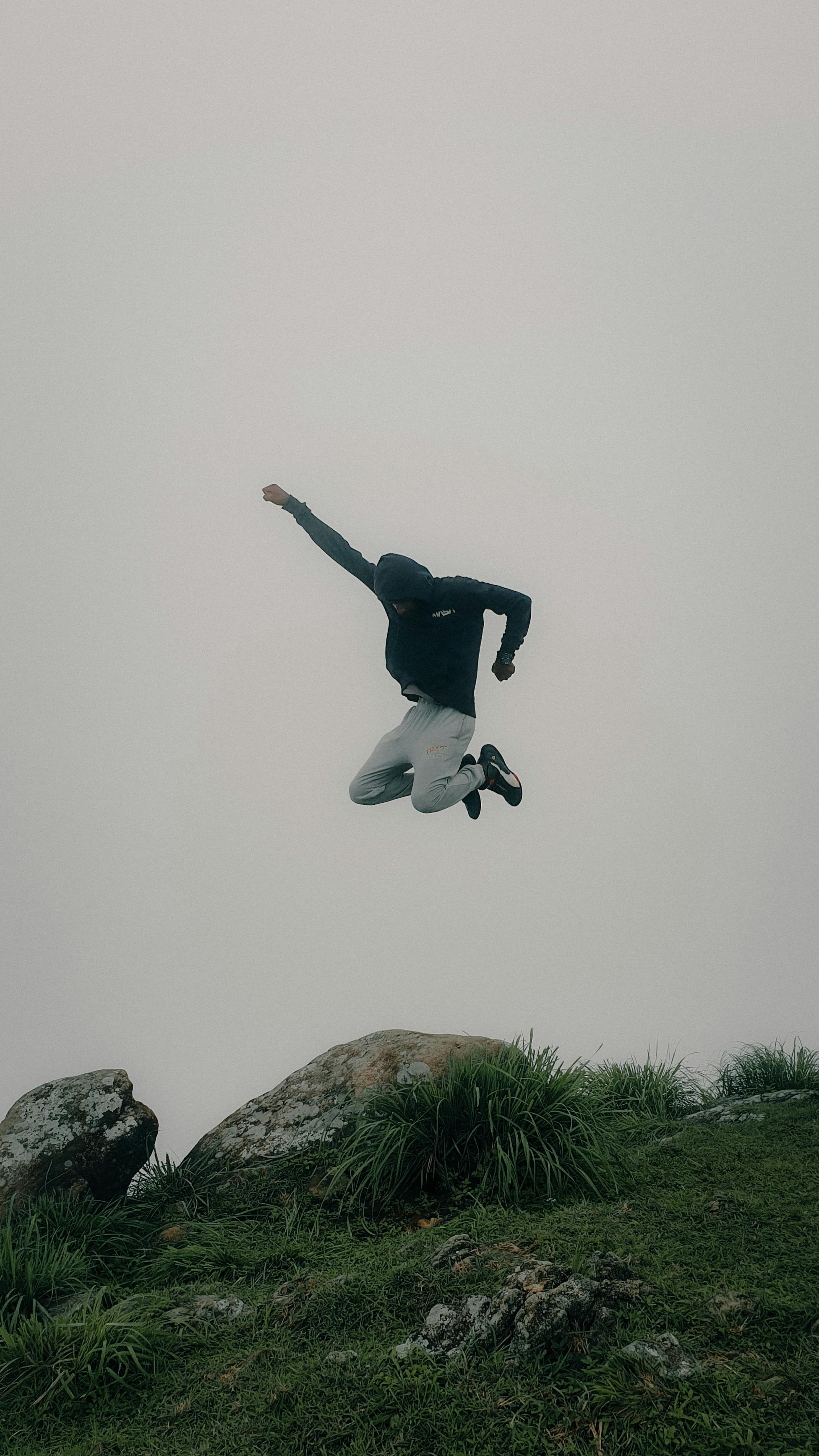 Man Jumping on Rocks Over a River · Free Stock Photo