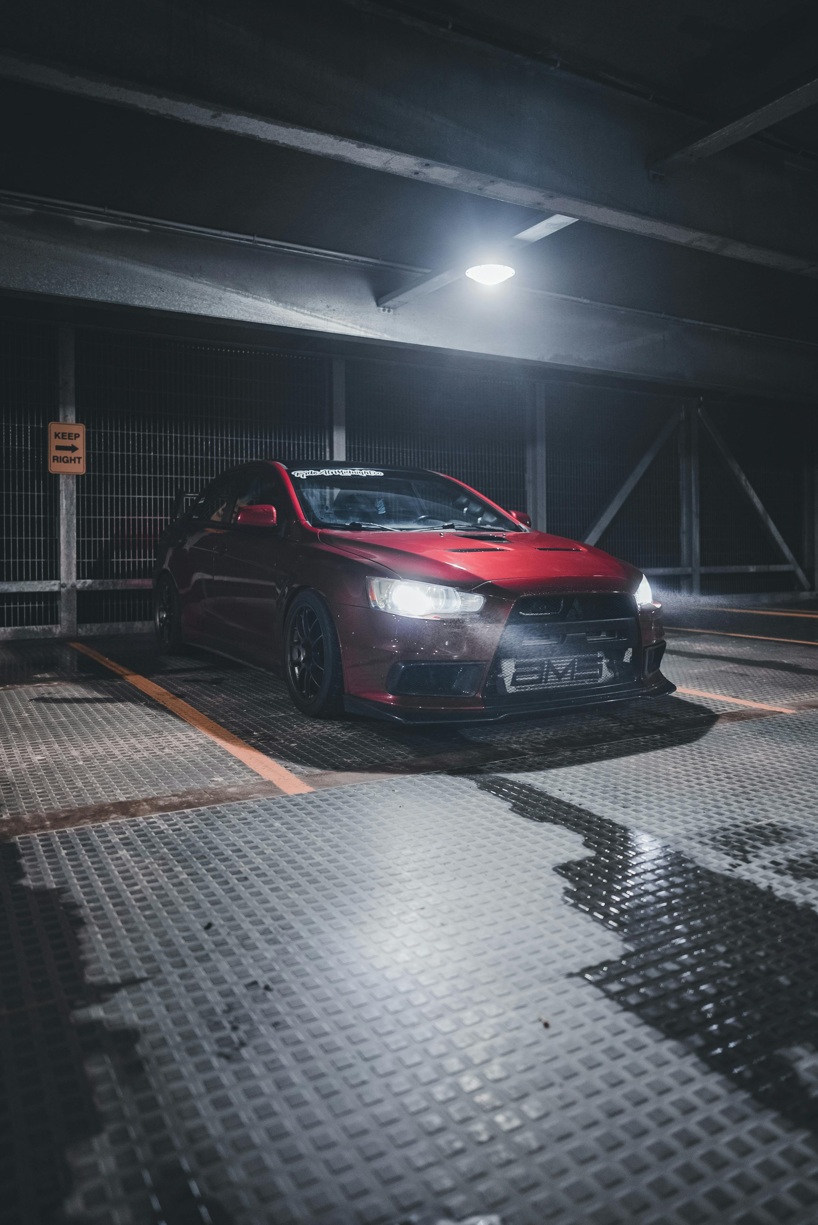 Red Mitsubishi Lancer Evolution with Headlights Turn on · Free Stock Photo