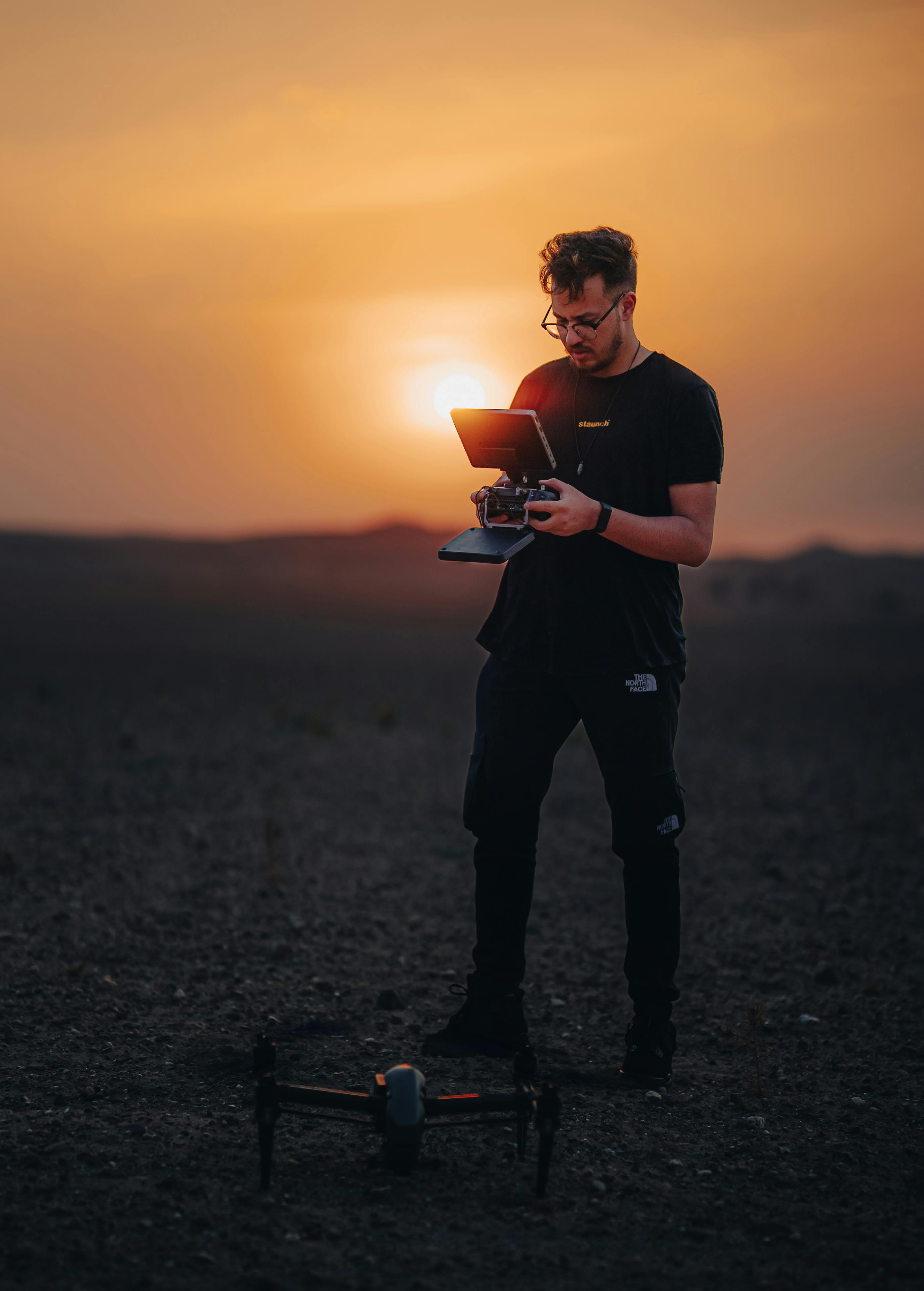 Man in Gray Jacket Holding Black Drone · Free Stock Photo