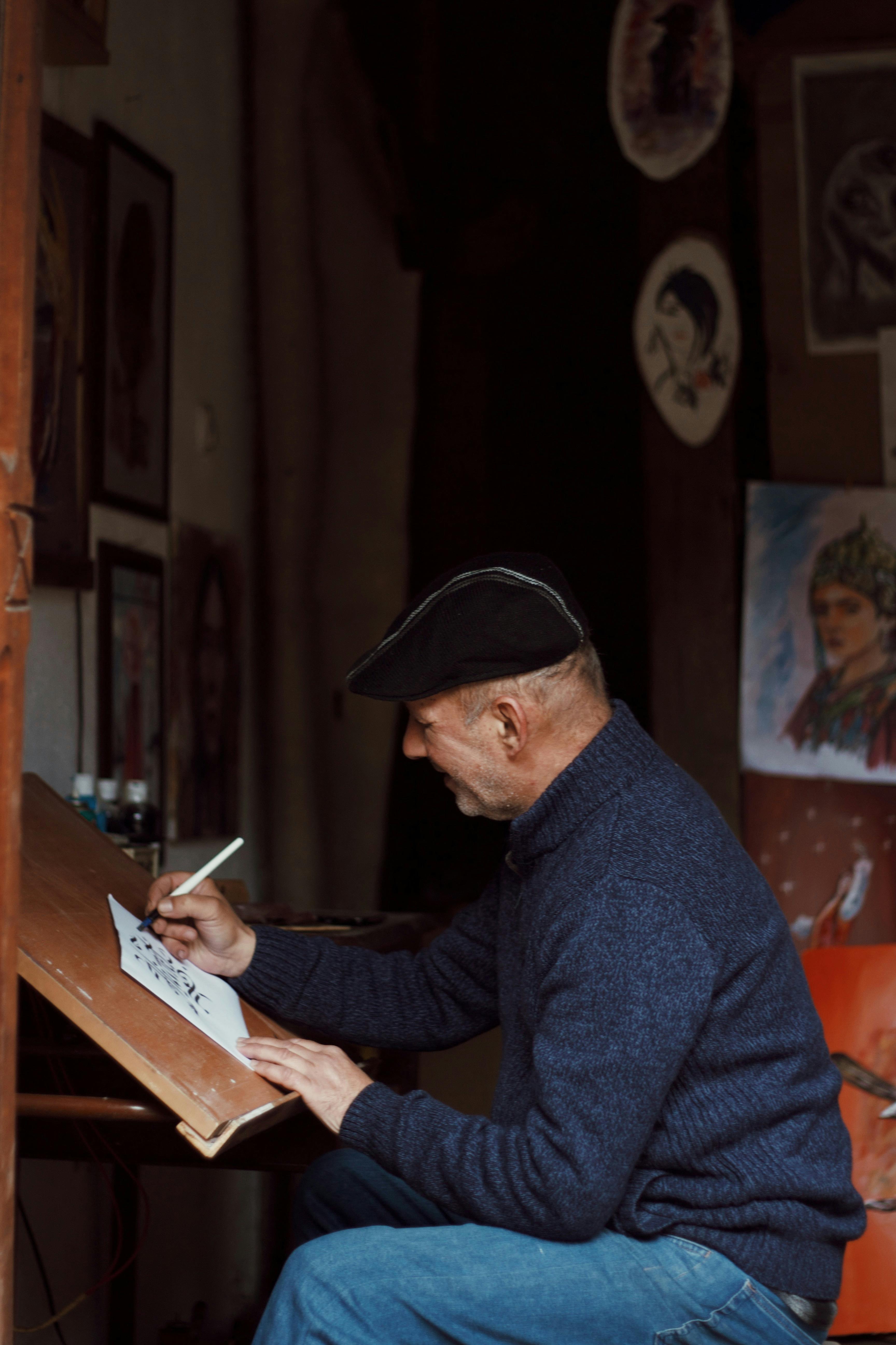 Happy Man Drawing on Paper · Free Stock Photo