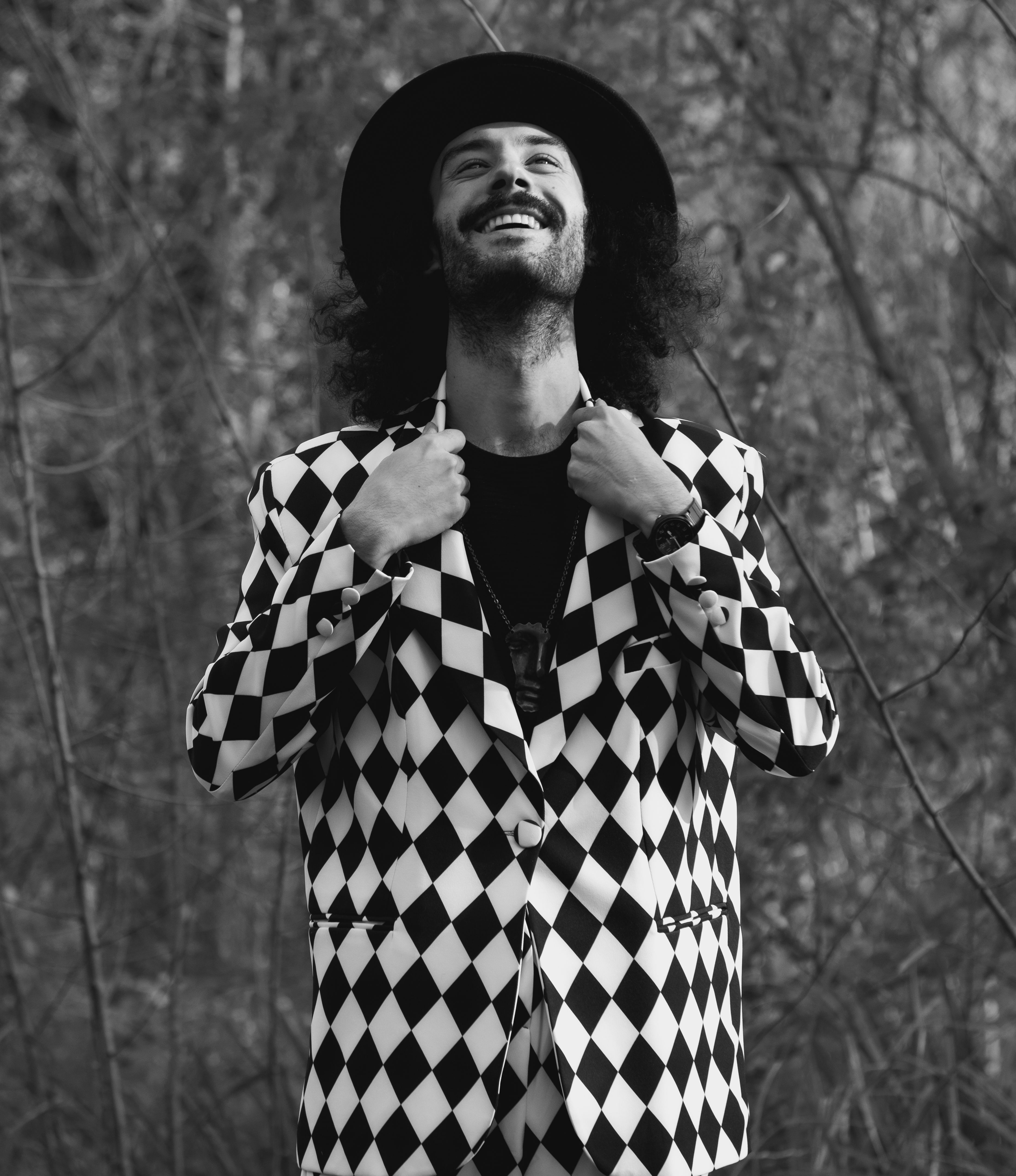 Man in a Patterned Suit and a Hat Posing Outdoors · Free Stock Photo