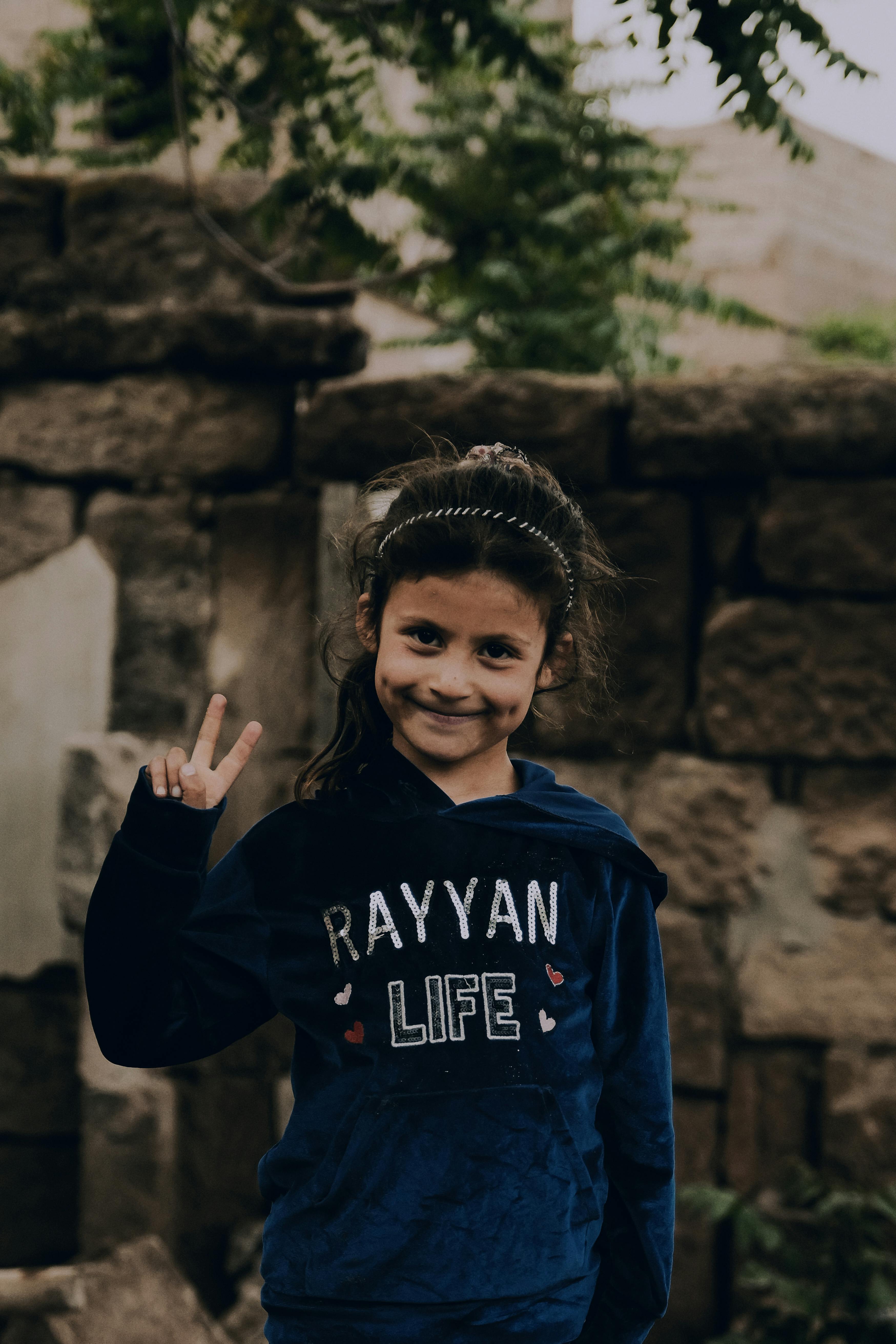 A young girl wearing a rayyan life sweatshirt · Free Stock Photo