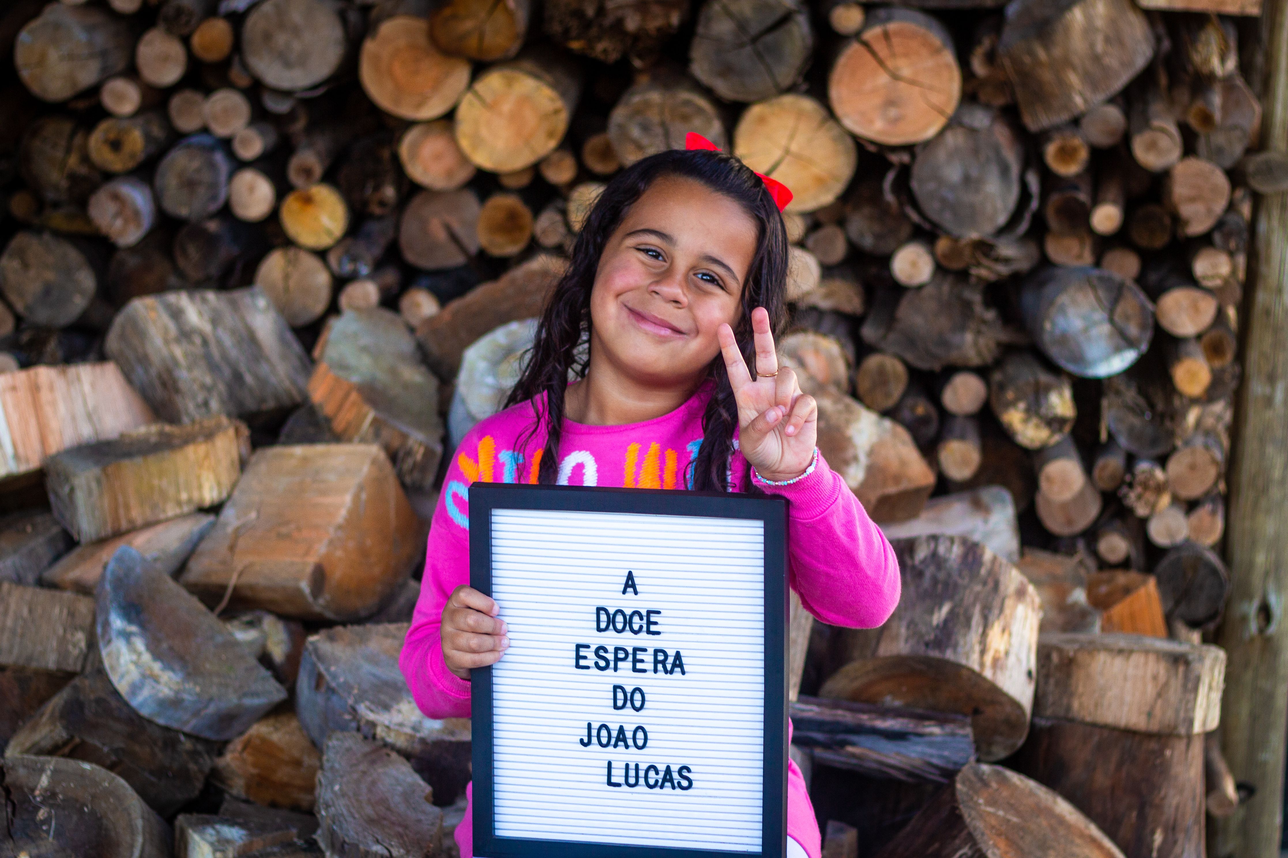 Girl Sitting on a Pile of Timber, Holding a Board with a Script · Free ...