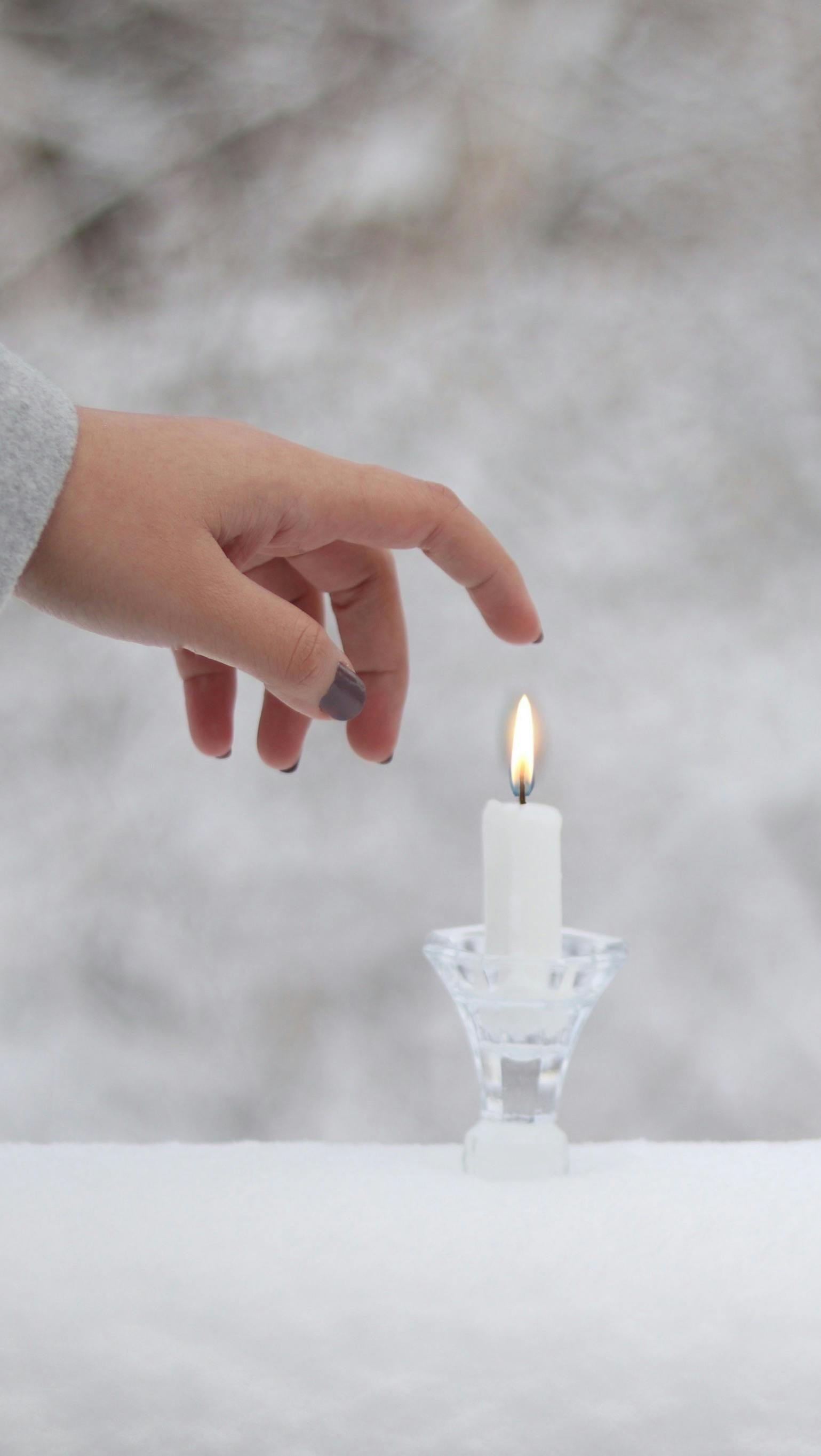 A Person Holding a Candle Snuffer · Free Stock Photo
