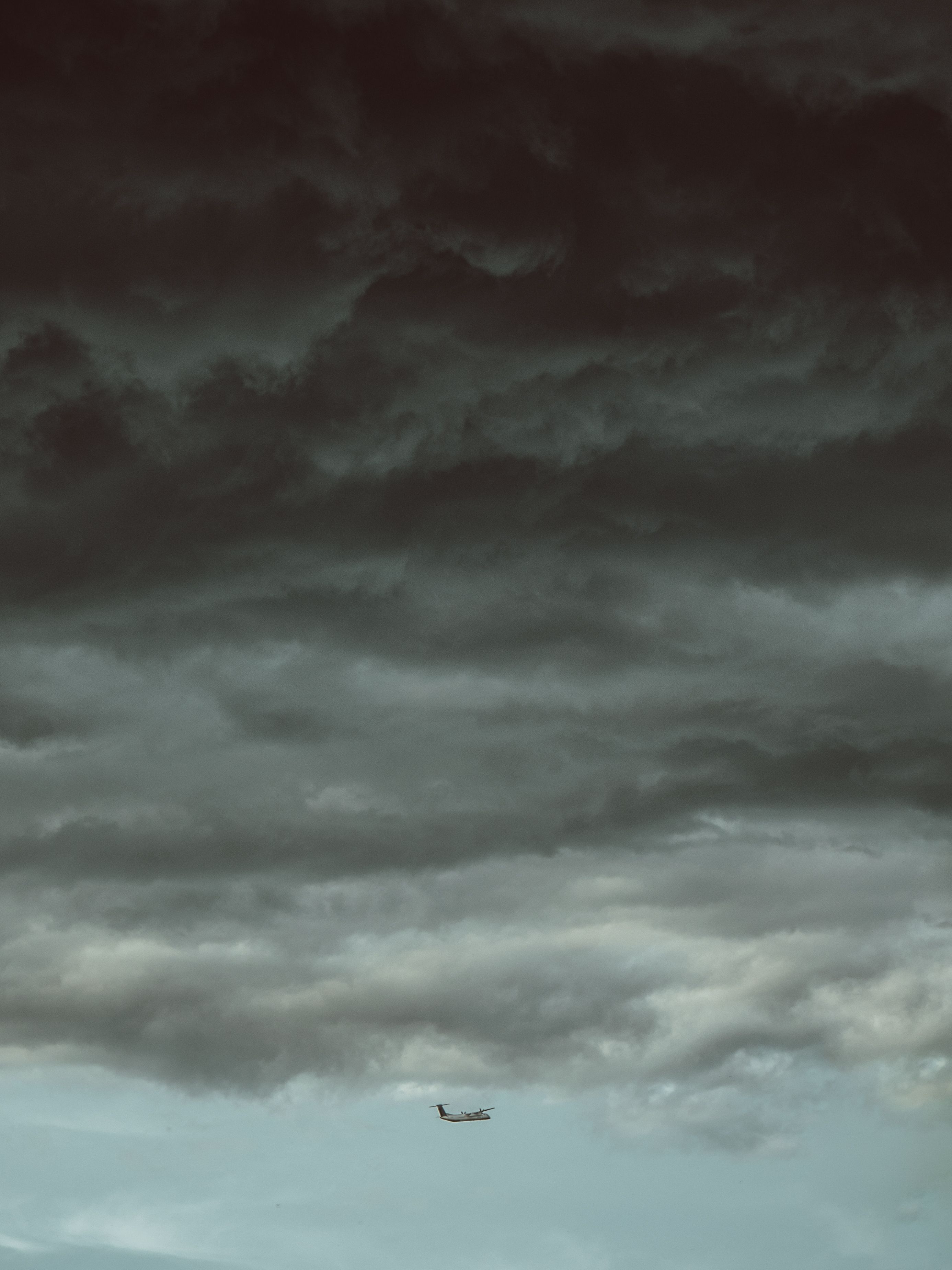 An Airplane Below Storm Clouds · Free Stock Photo