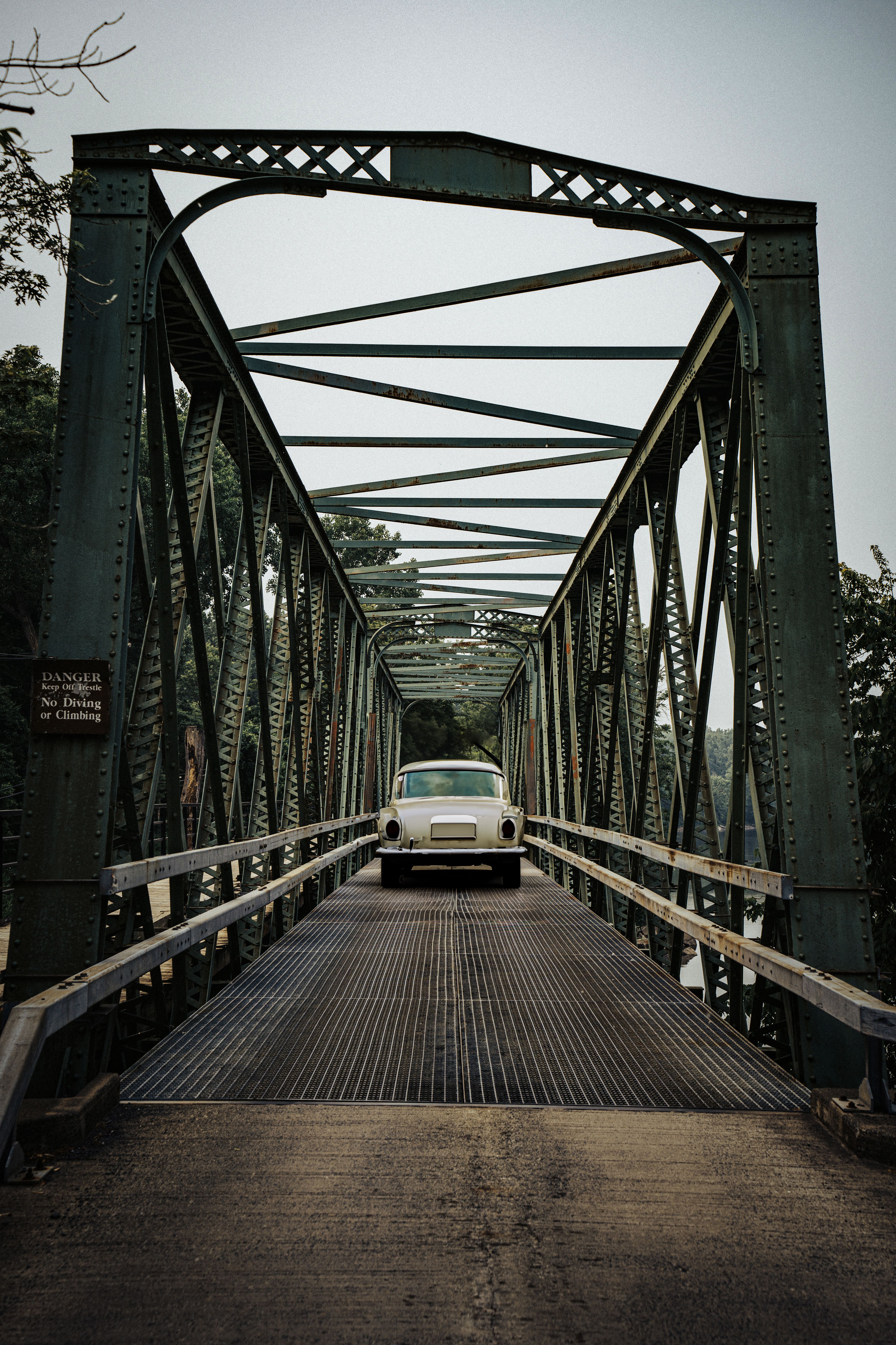 A car is driving on a bridge over a river · Free Stock Photo