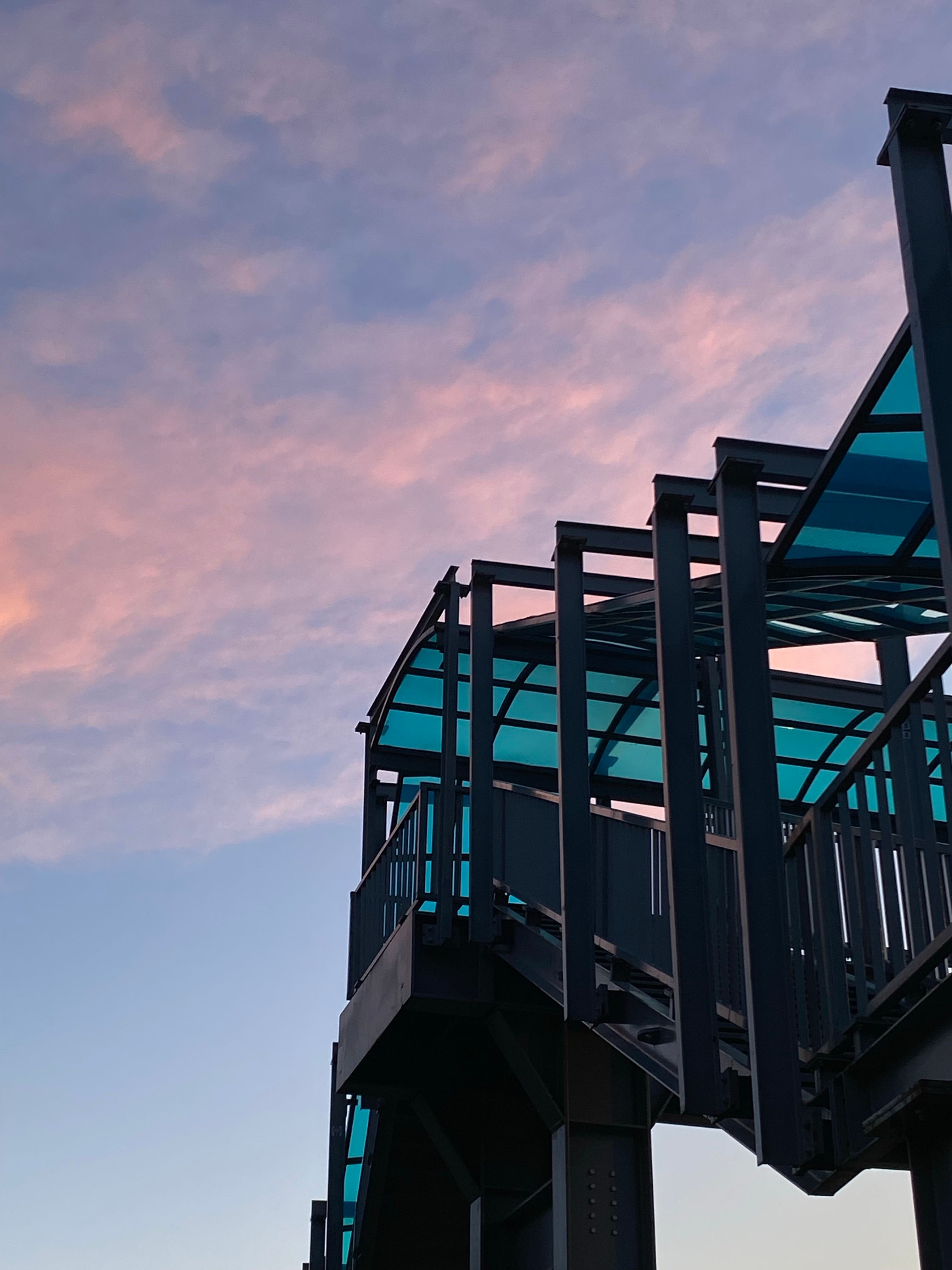 A metal walkway with a blue sky and pink clouds · Free Stock Photo