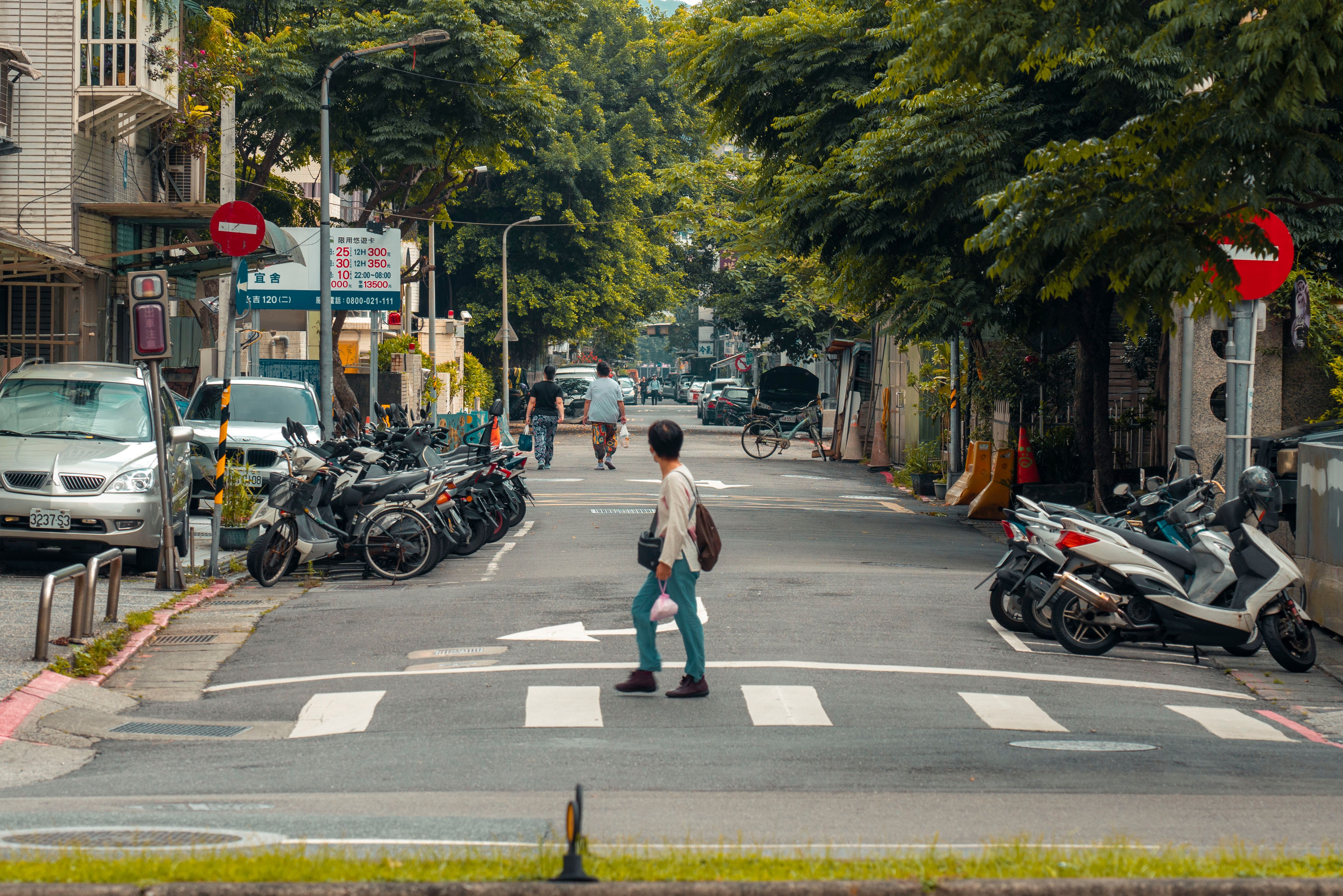 A Pedestrian Crossing the Street in City · Free Stock Photo
