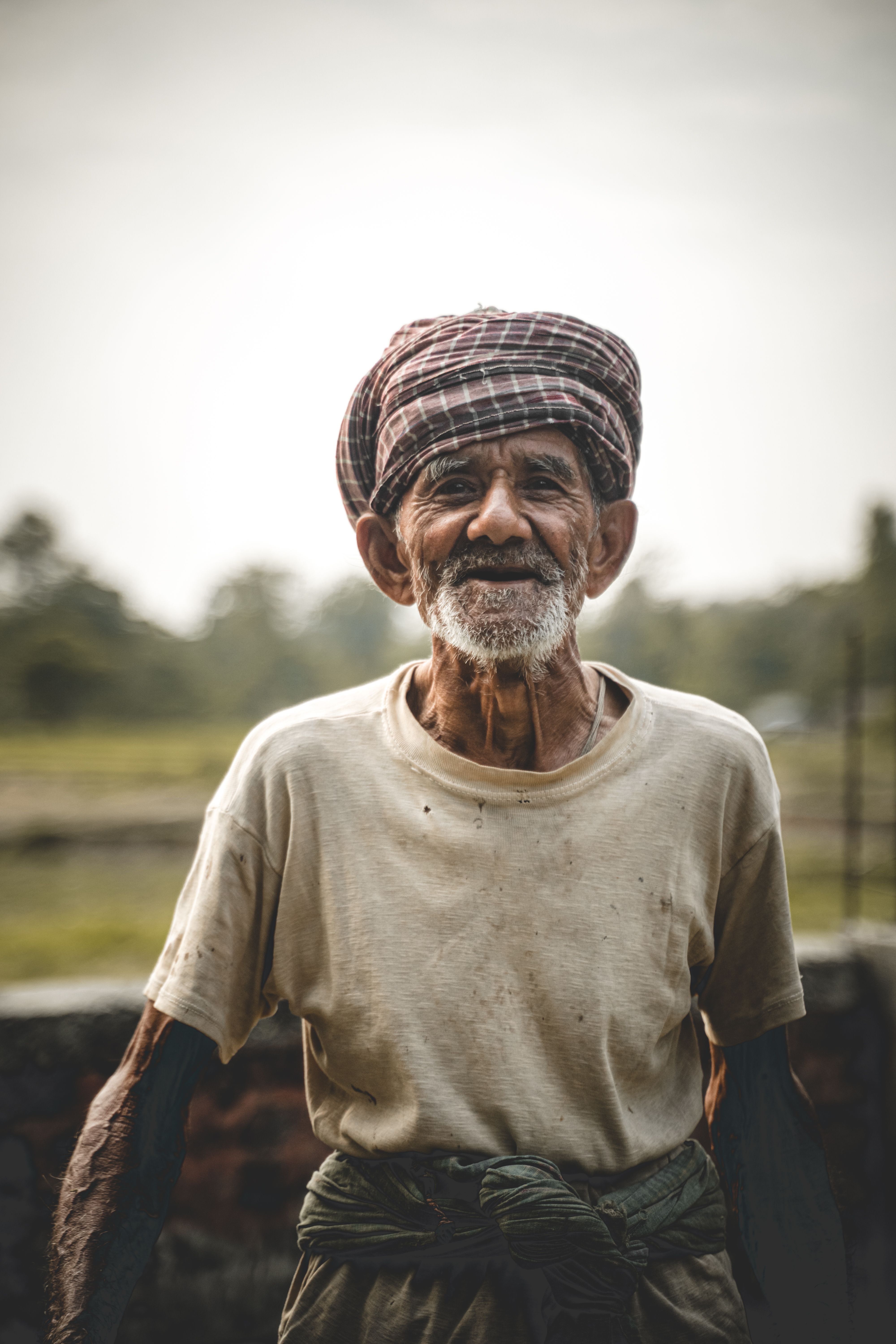 Portrait of Sitting Smiling Man with Bucket Hat · Free Stock Photo