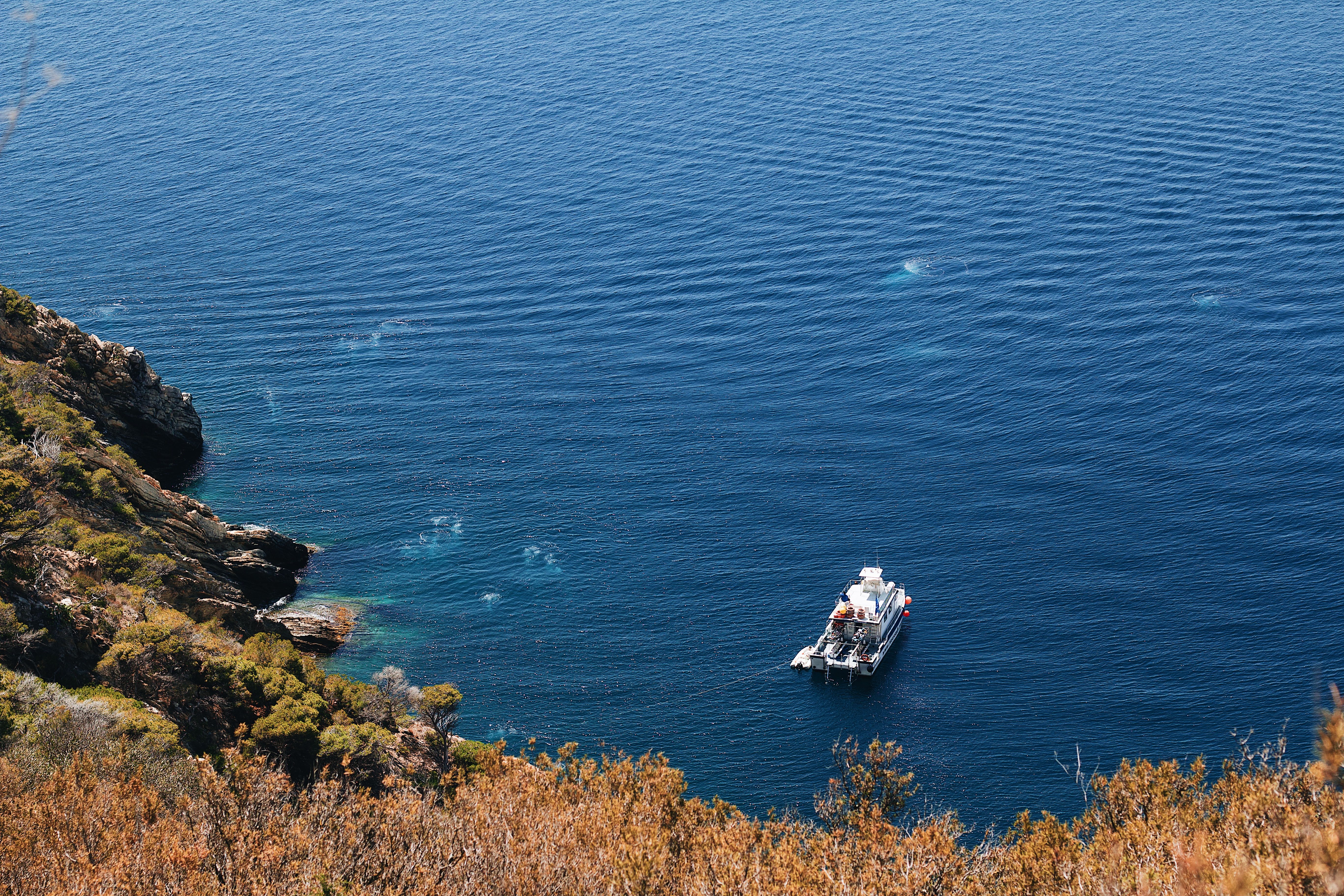 A boat is sailing on the water near a cliff · Free Stock Photo