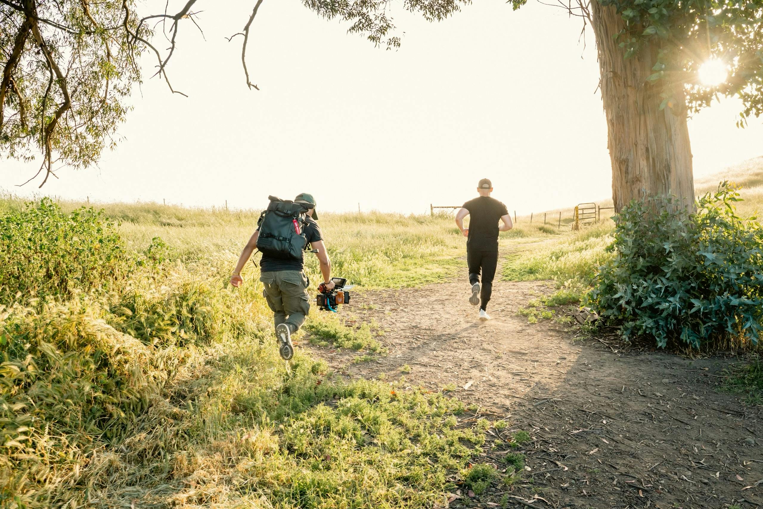 Cameraman Recording Runner in Countryside · Free Stock Photo