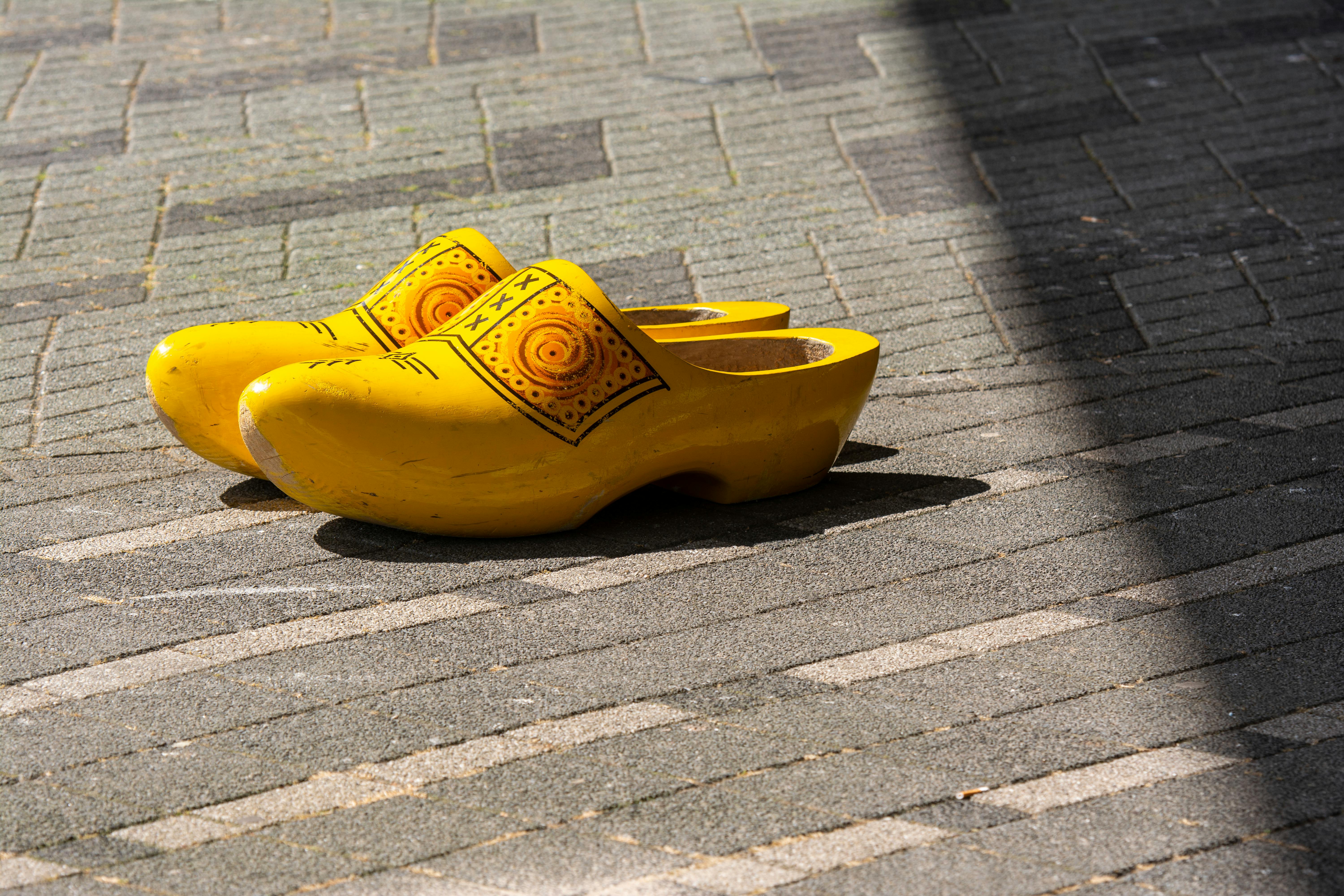Yellow Clogs on the Pavement · Free Stock Photo
