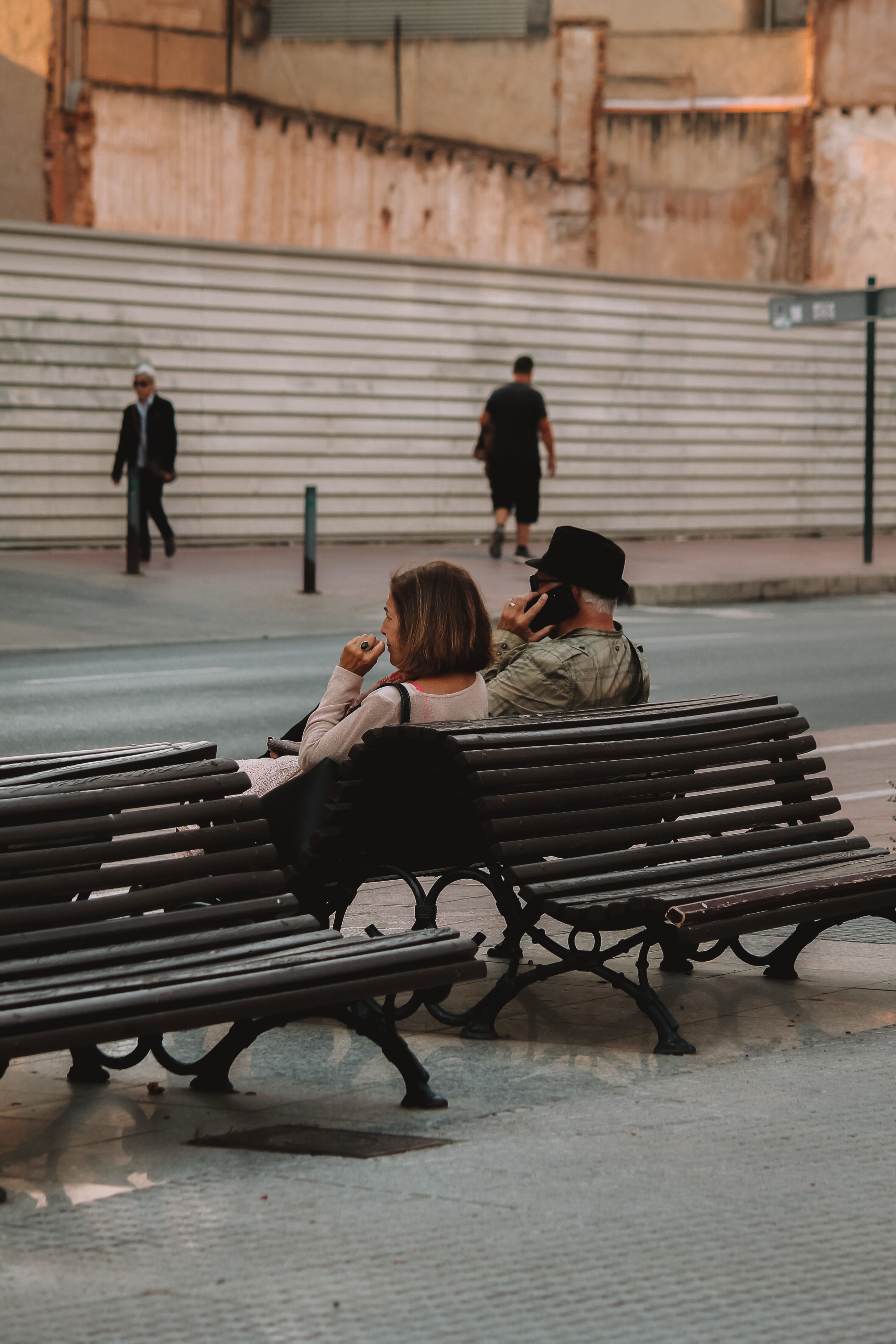 People Sitting on Benches near Street · Free Stock Photo